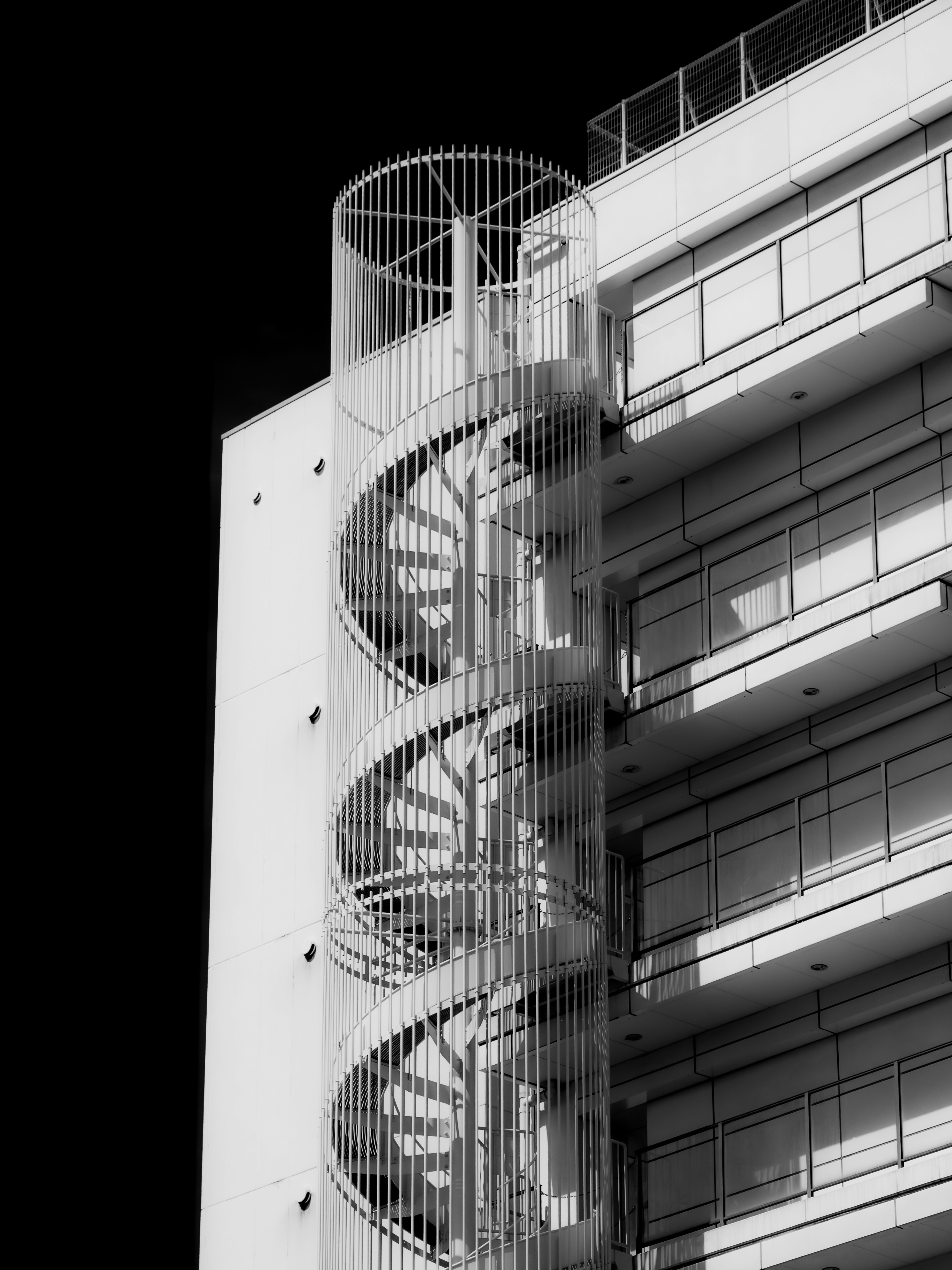 Vertical Spiral: A Nighttime Facade Framed by Steel Ribs