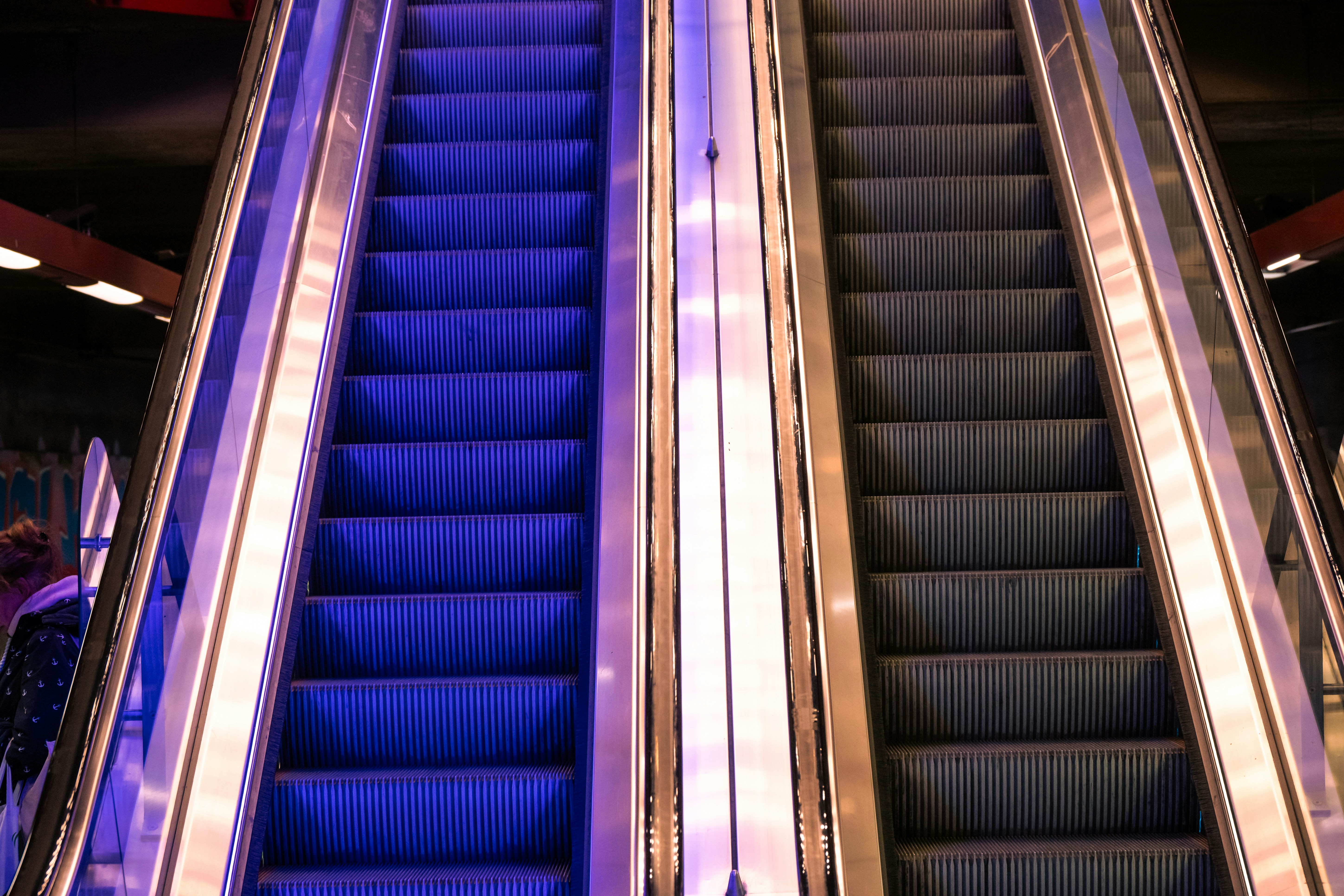 Symmetry in Motion: Neon-Trimmed Escalators in a Quiet Public Space