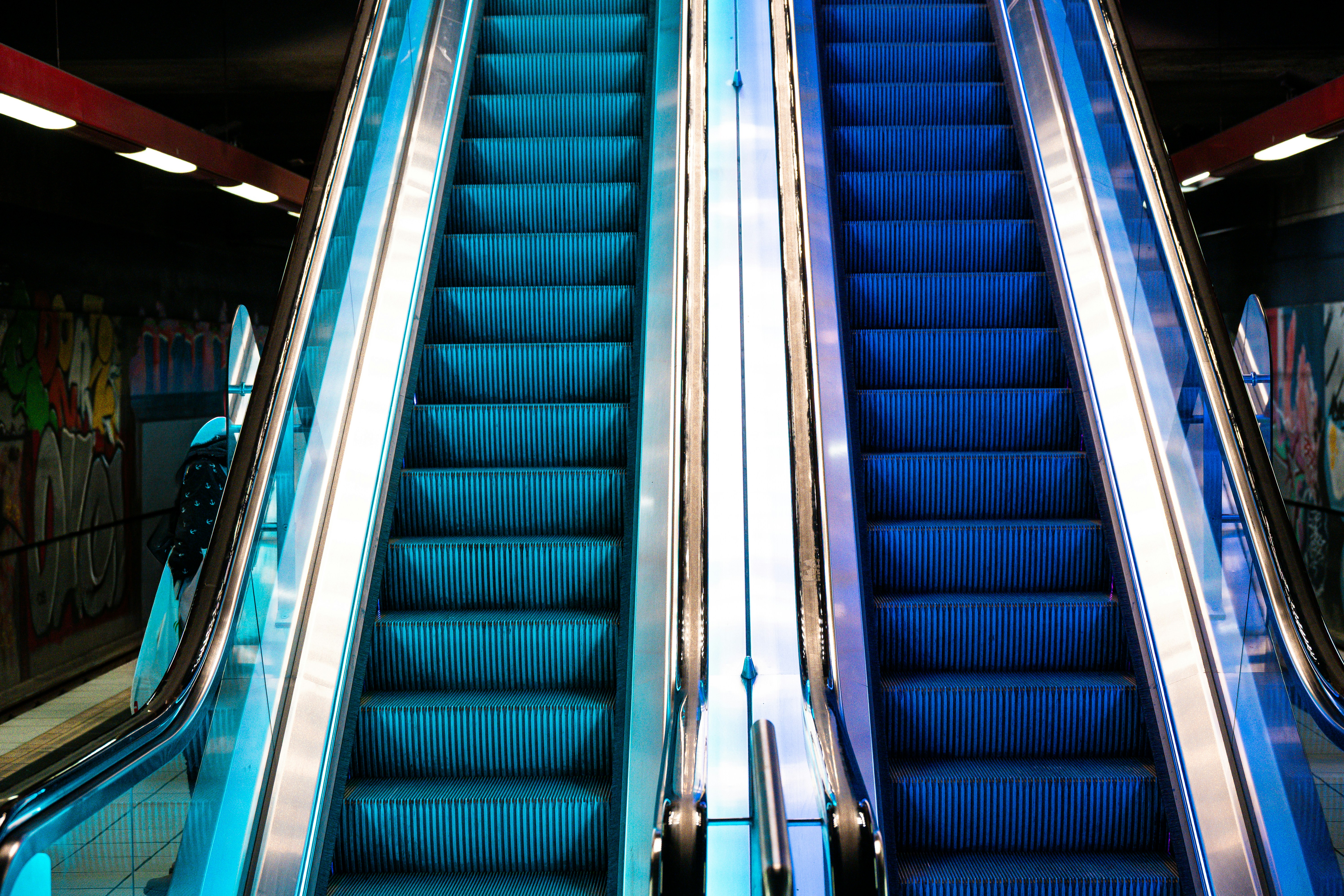 Symmetry at Ground Level: Twin Escalators Ascend in Neon Rhythm