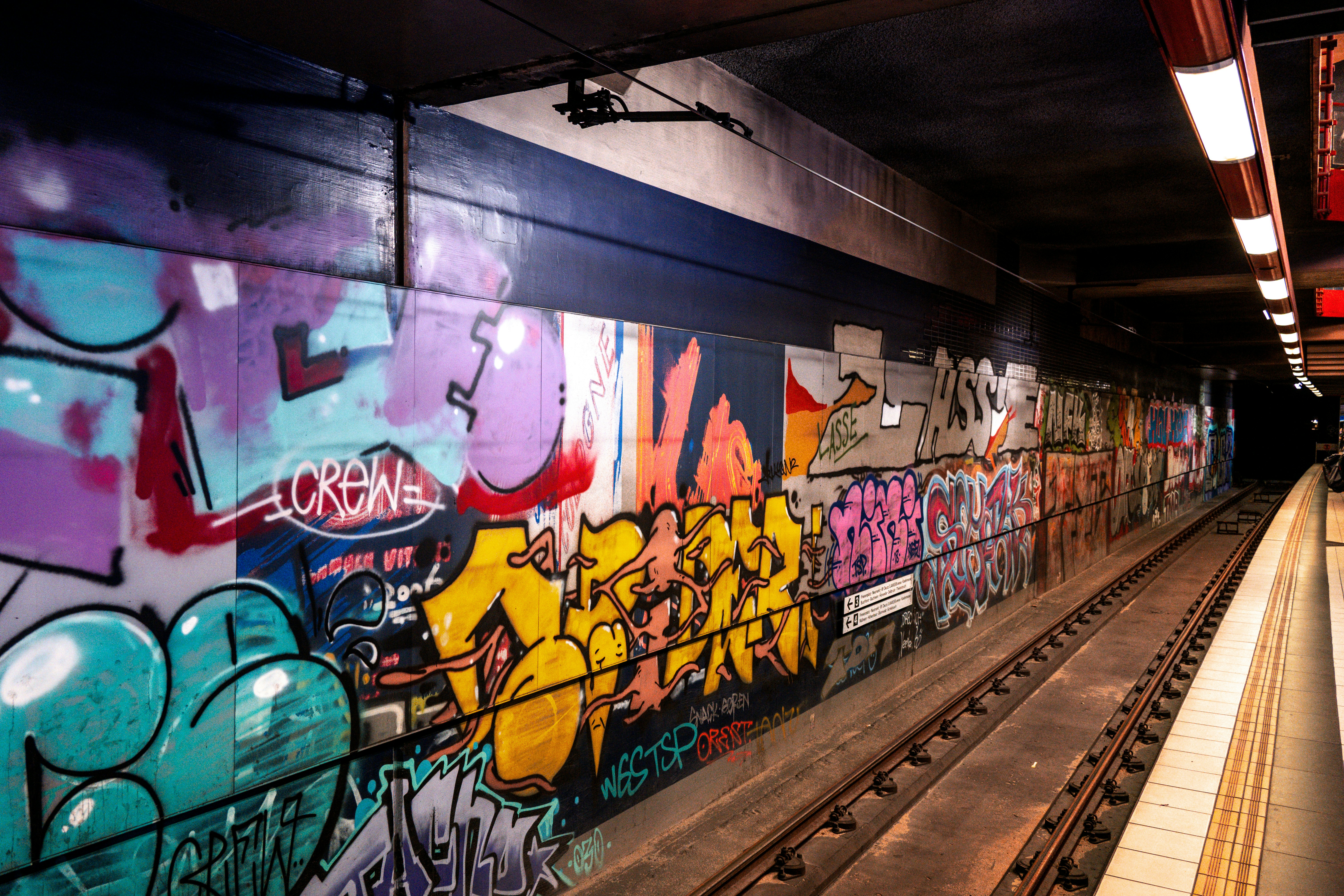 Graffitied Tunnel: a bright corridor of rail with chromatic murals fading into the distance