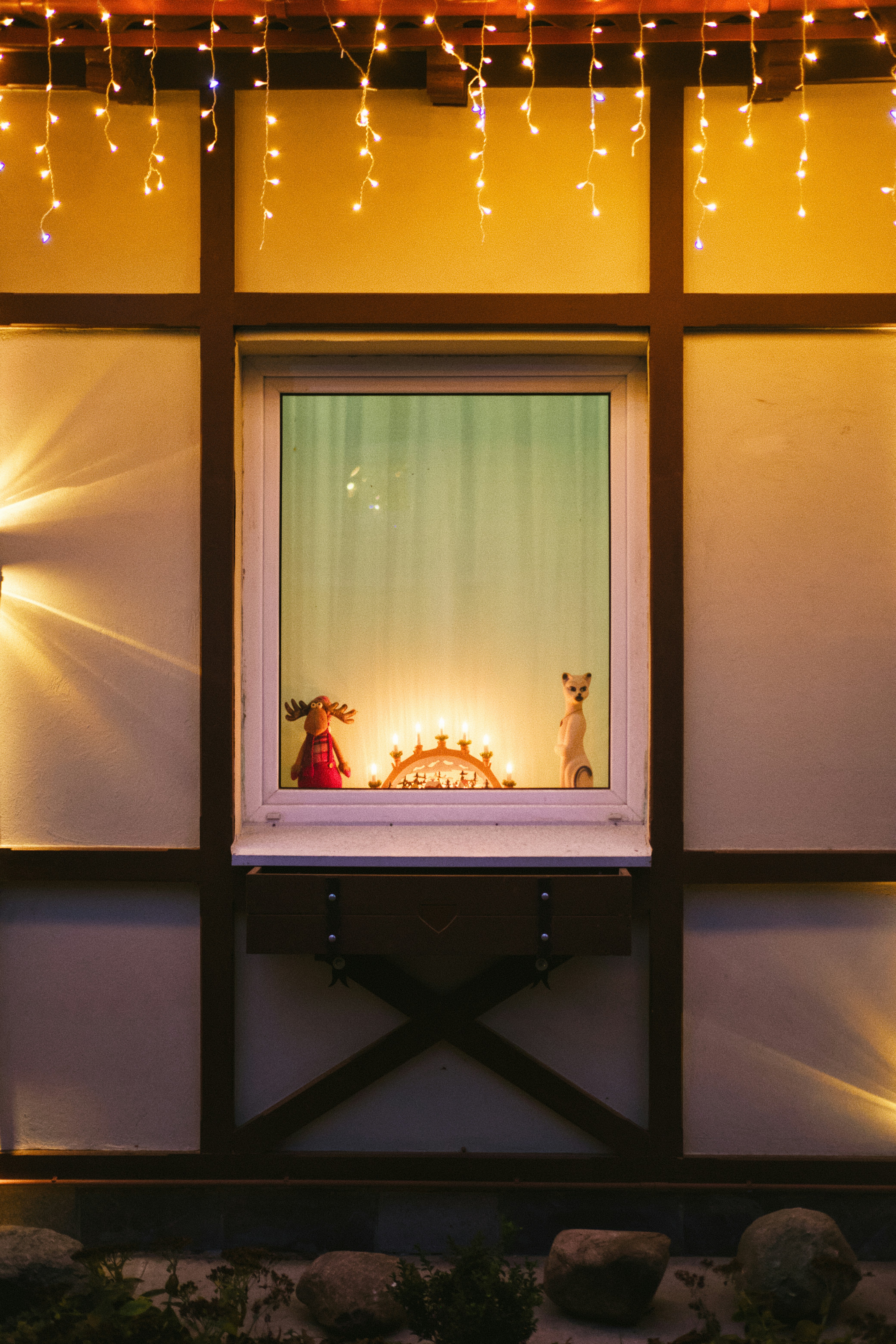 Window of Warmth: Festive Figures in a Lit Crest