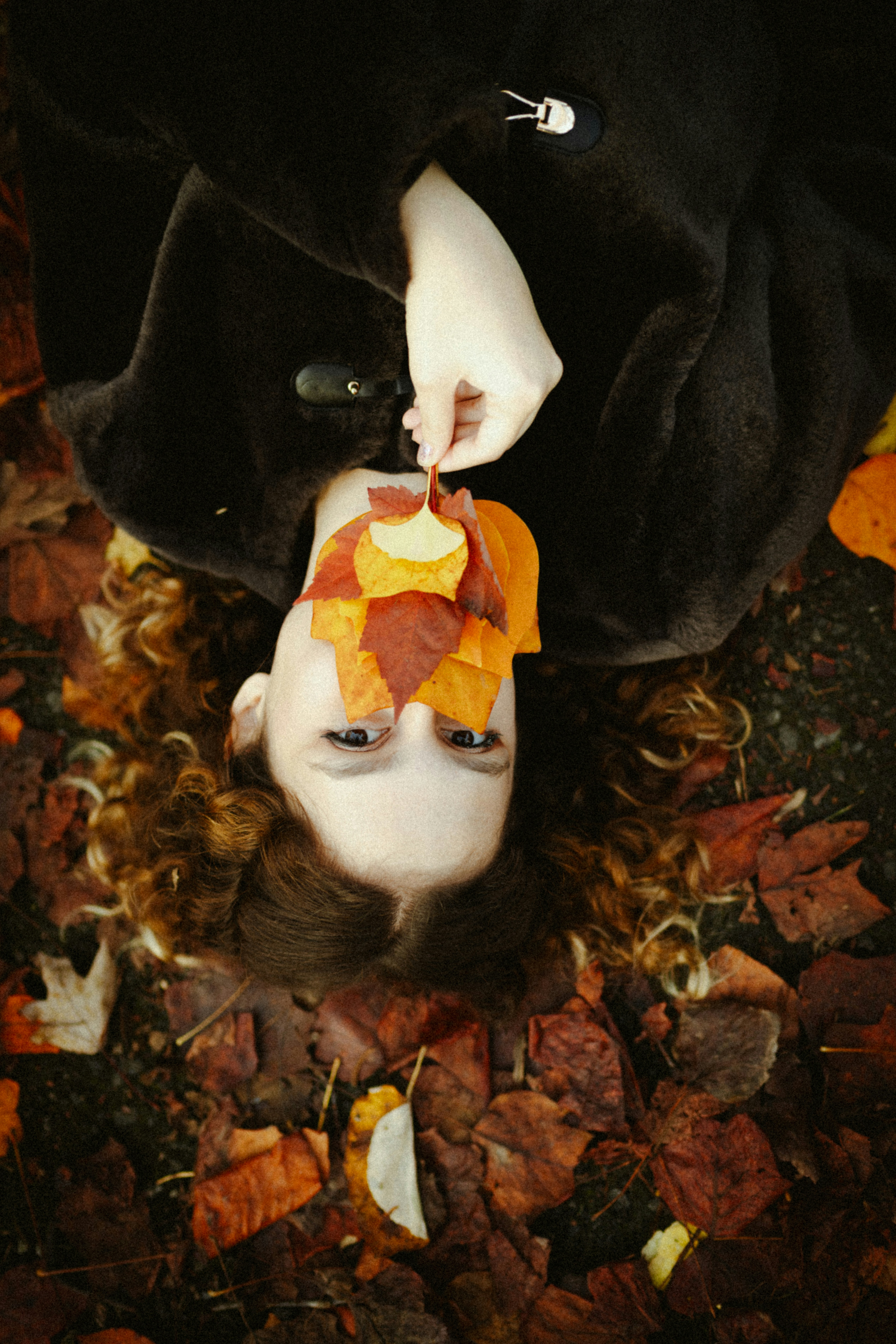 Autumn Confession: A Child’s Quiet Kiss of Fall Leaves