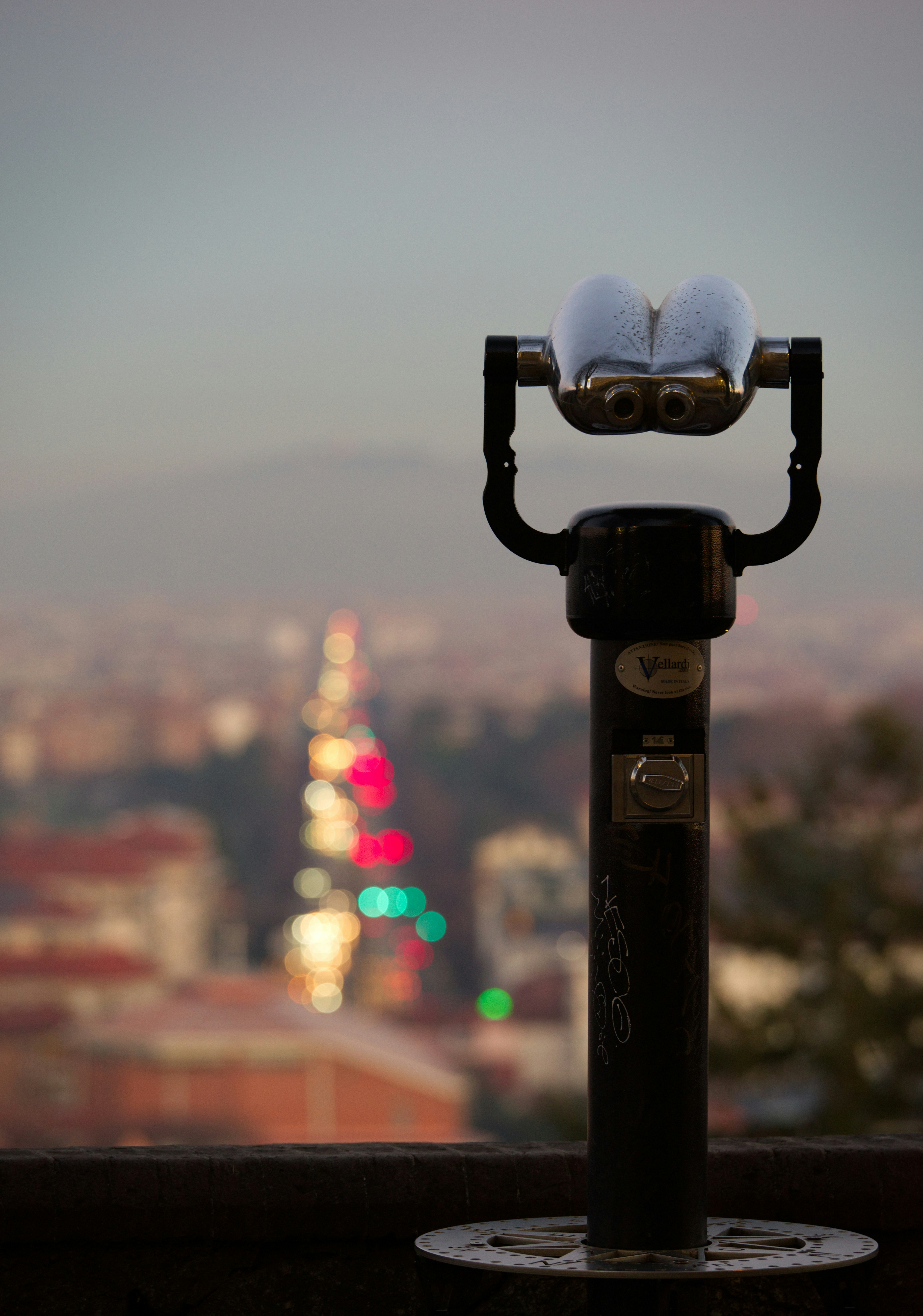 Cityview Telephoto: A Binocular Viewpoint on a Snowy Coin-operated Scope Overlooking a Distant Skyline