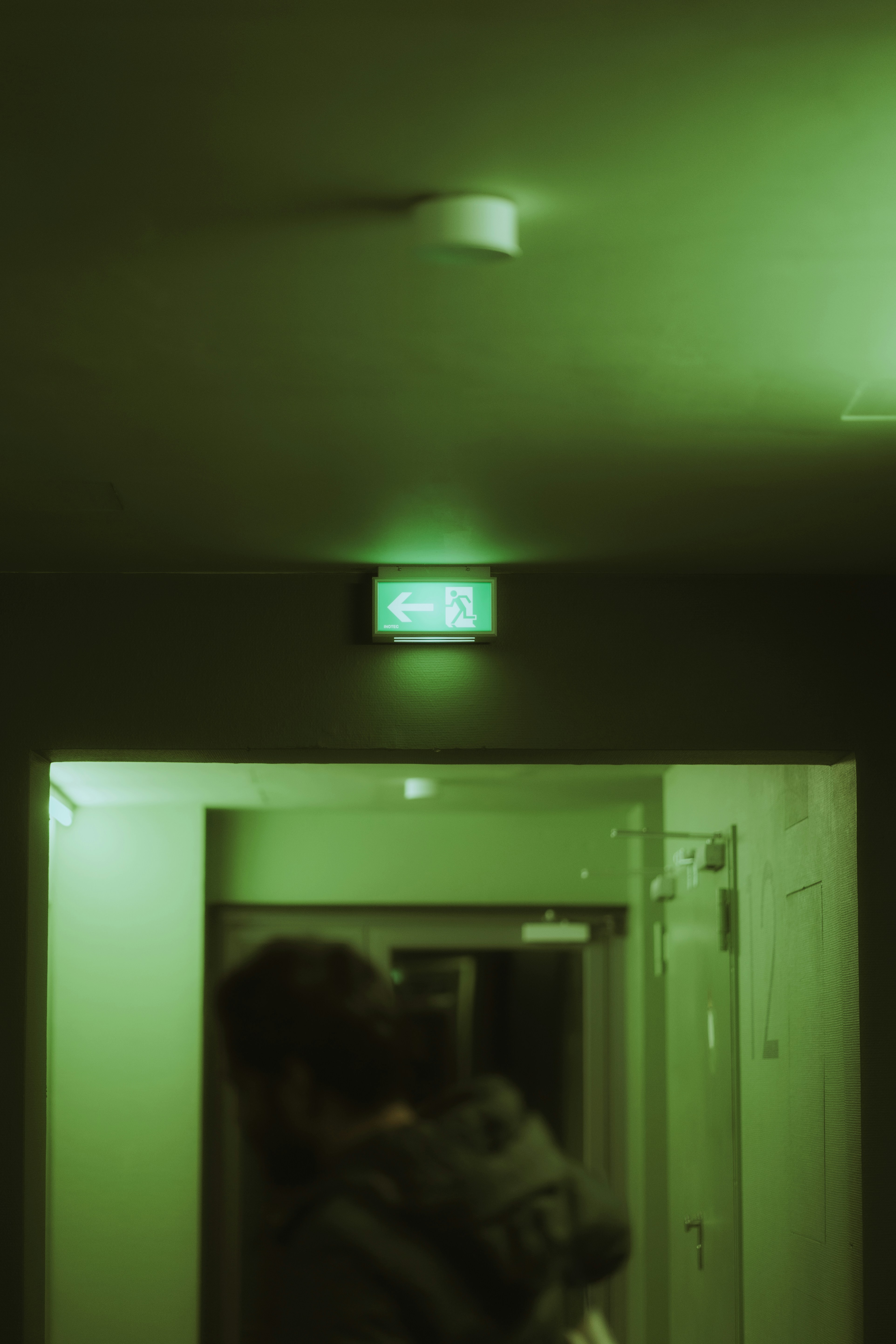 Green-tinged Exit: Silent Corridor with Looming Motion Blur