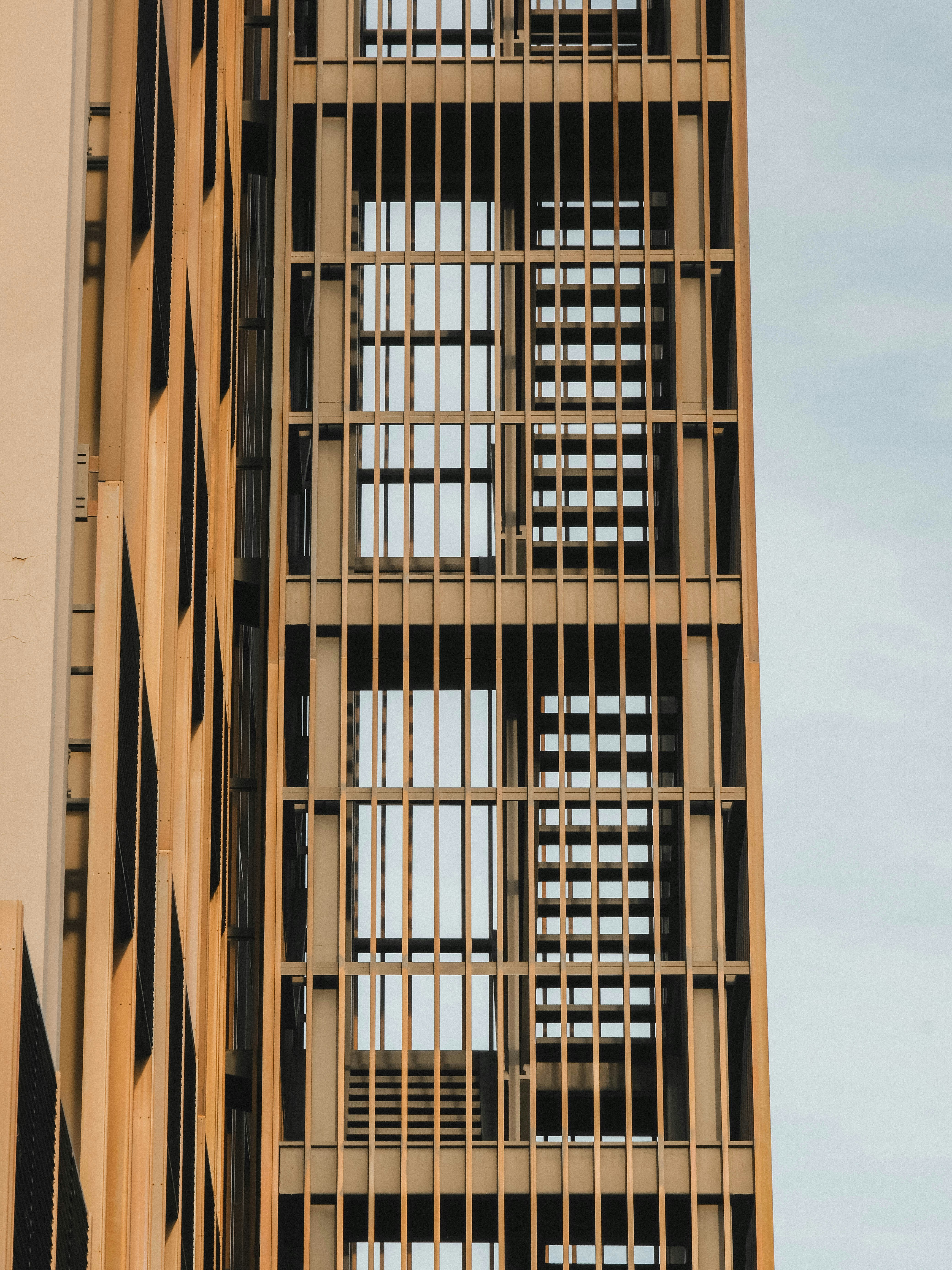 Vertical Gridwork: A Tan Facade Framed by Sky