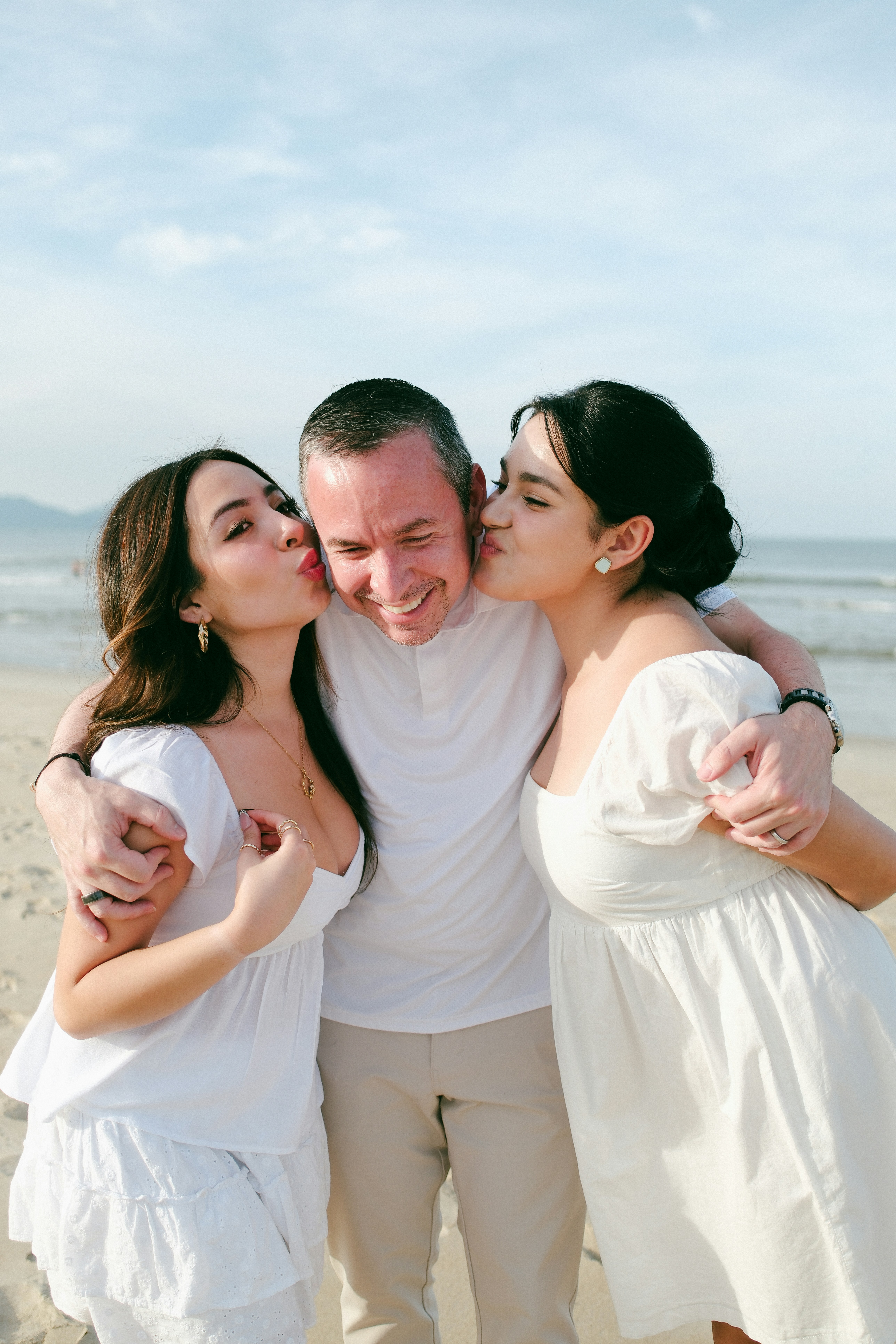 Group Hug on the Seashore: A Trio in White