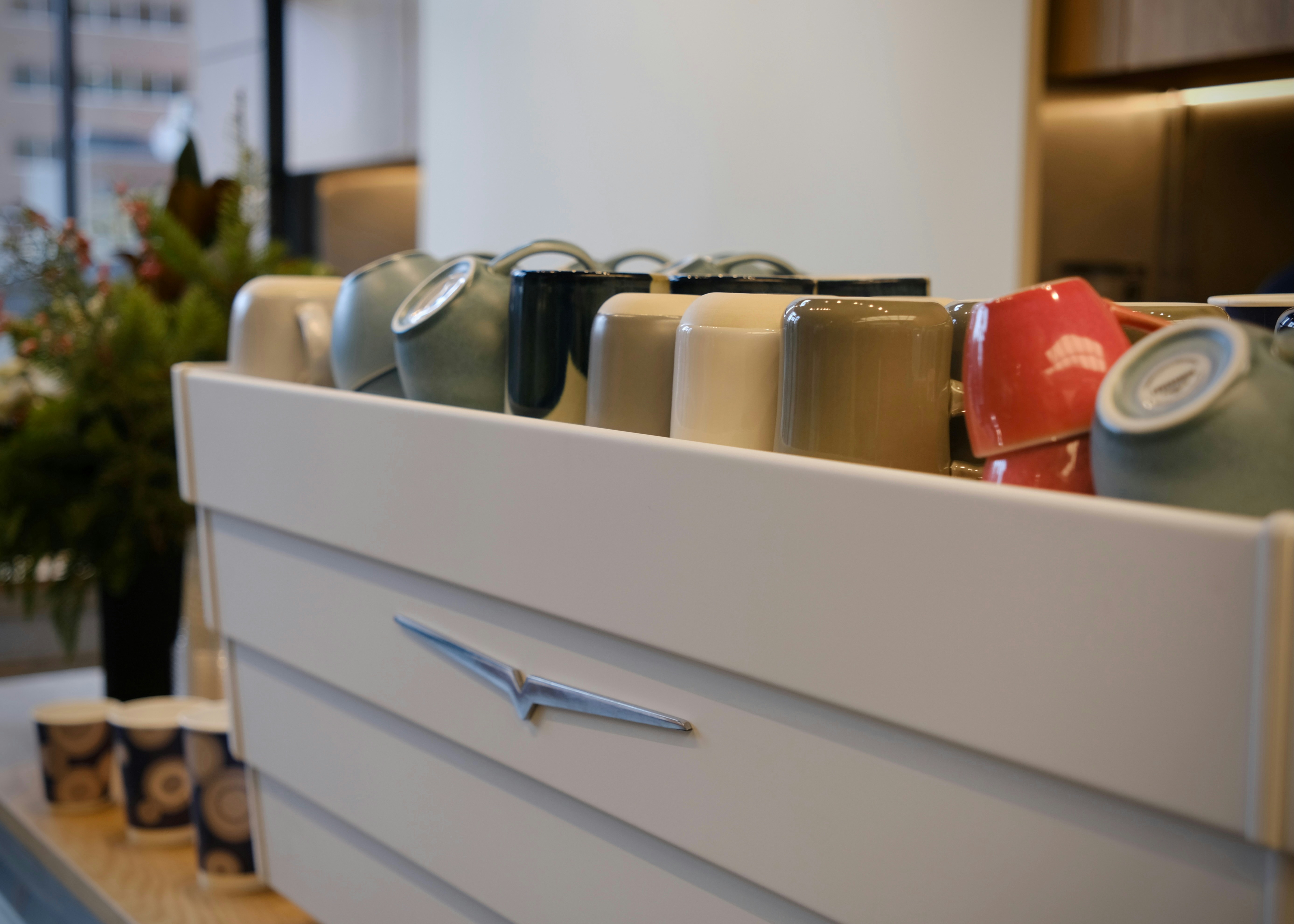 Mug Row on a White Service Counter at a Modern Café
