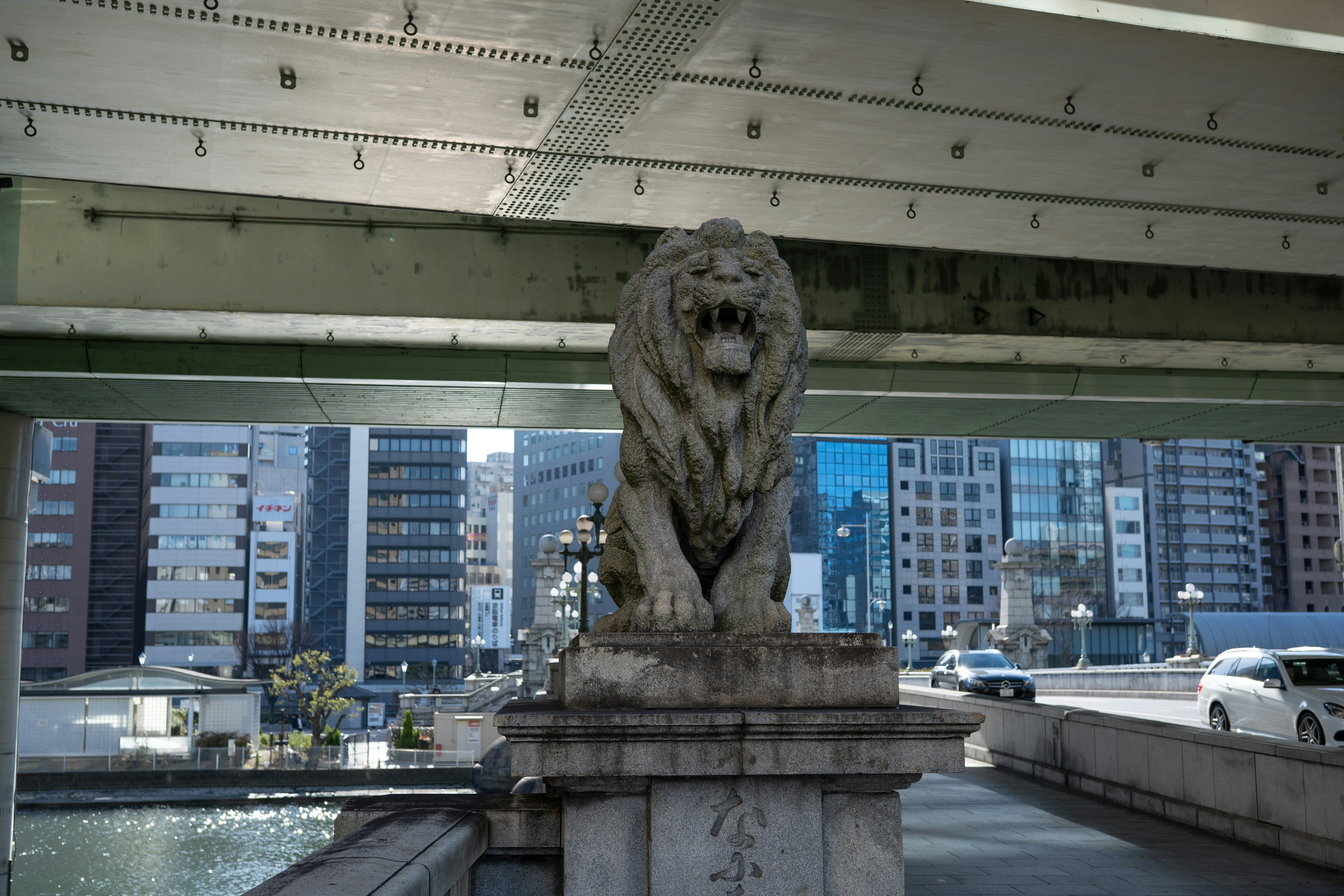 Lion Guardian Beneath the Steel Bridge Overlooking a Modern City