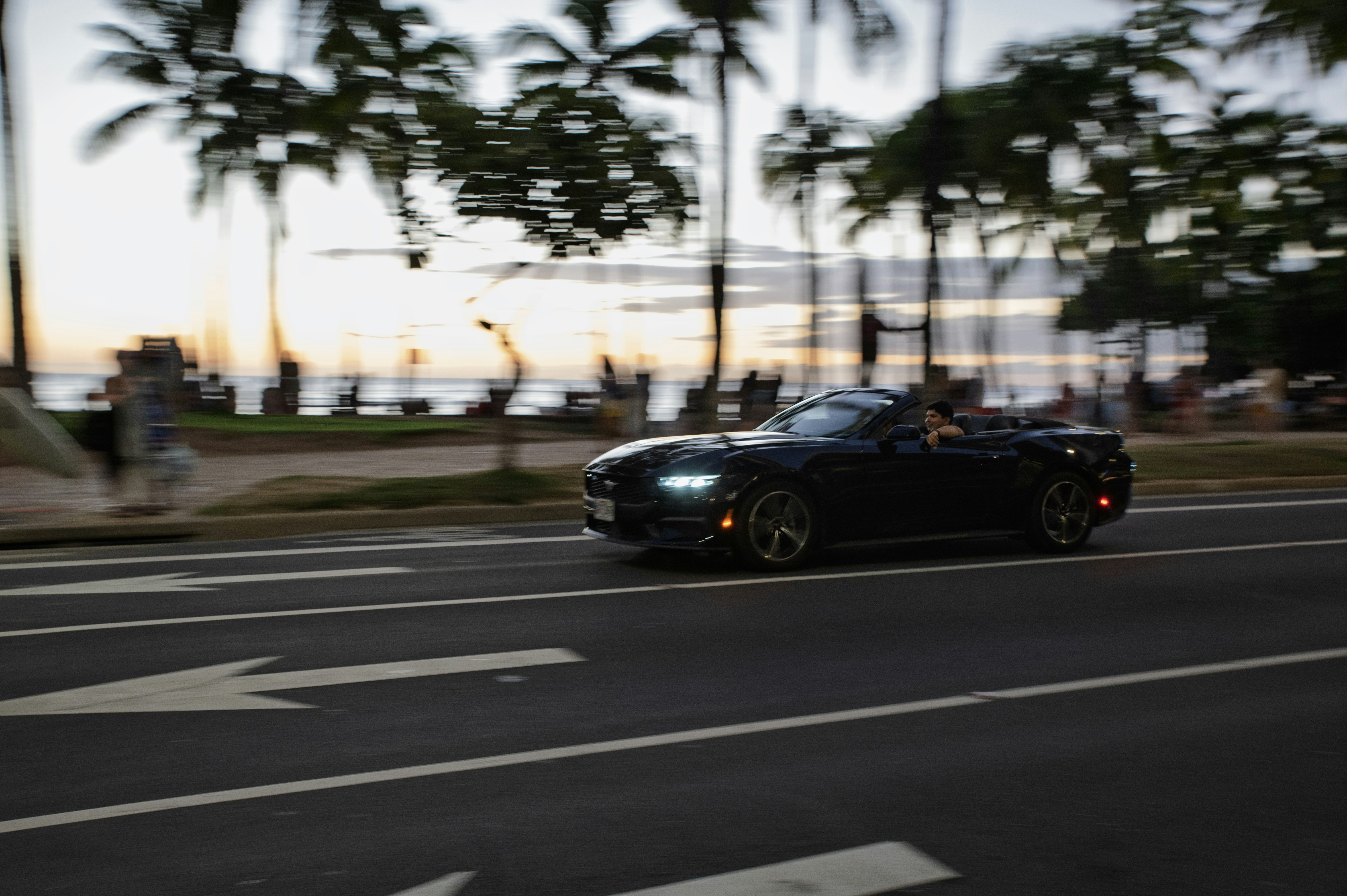 Midnight Coastline: Convertible Blur Racing Along a Palm-Rowed Boulevard