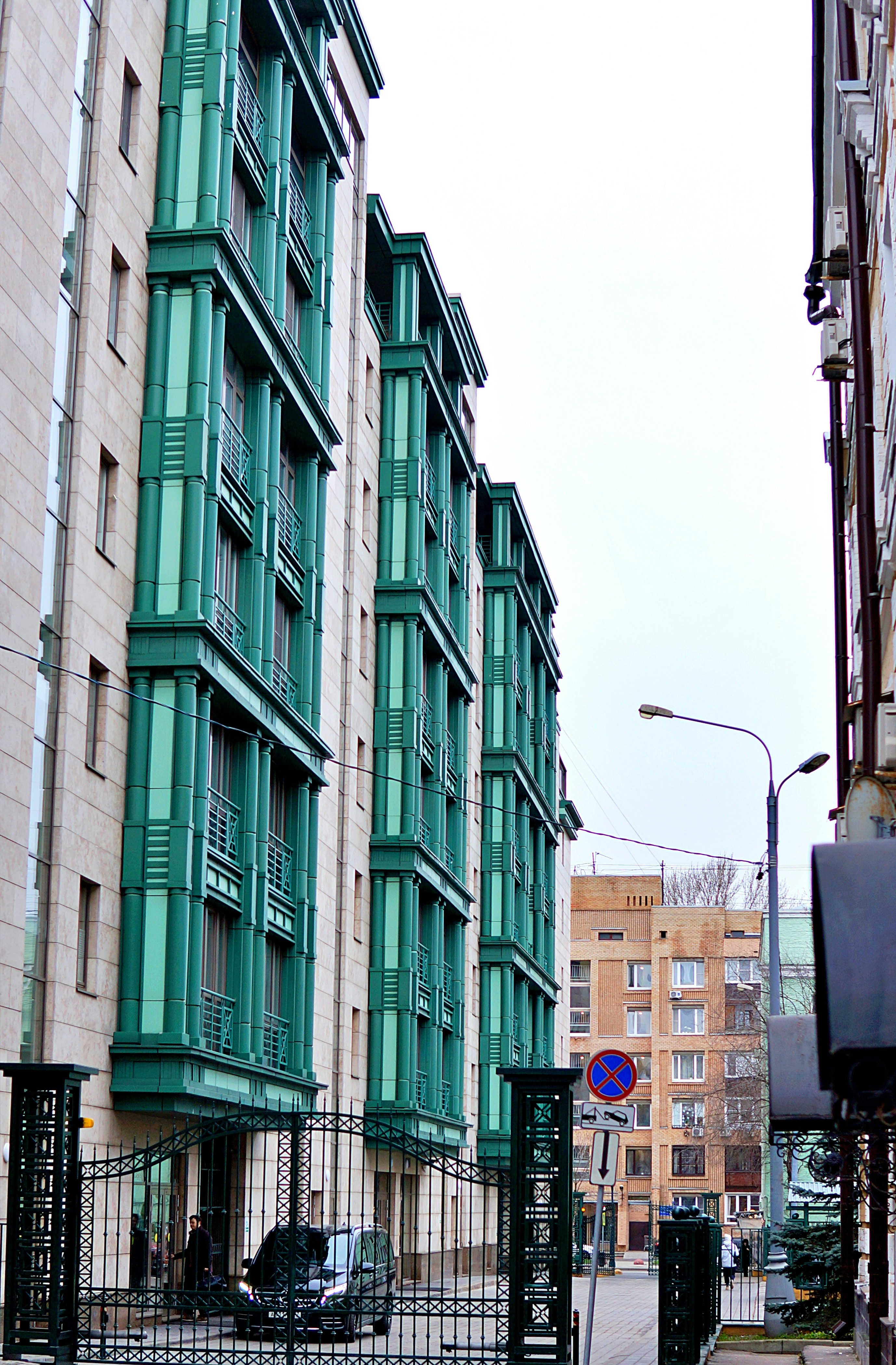 Green Facade Towers: Urban Street vista with teal balconies