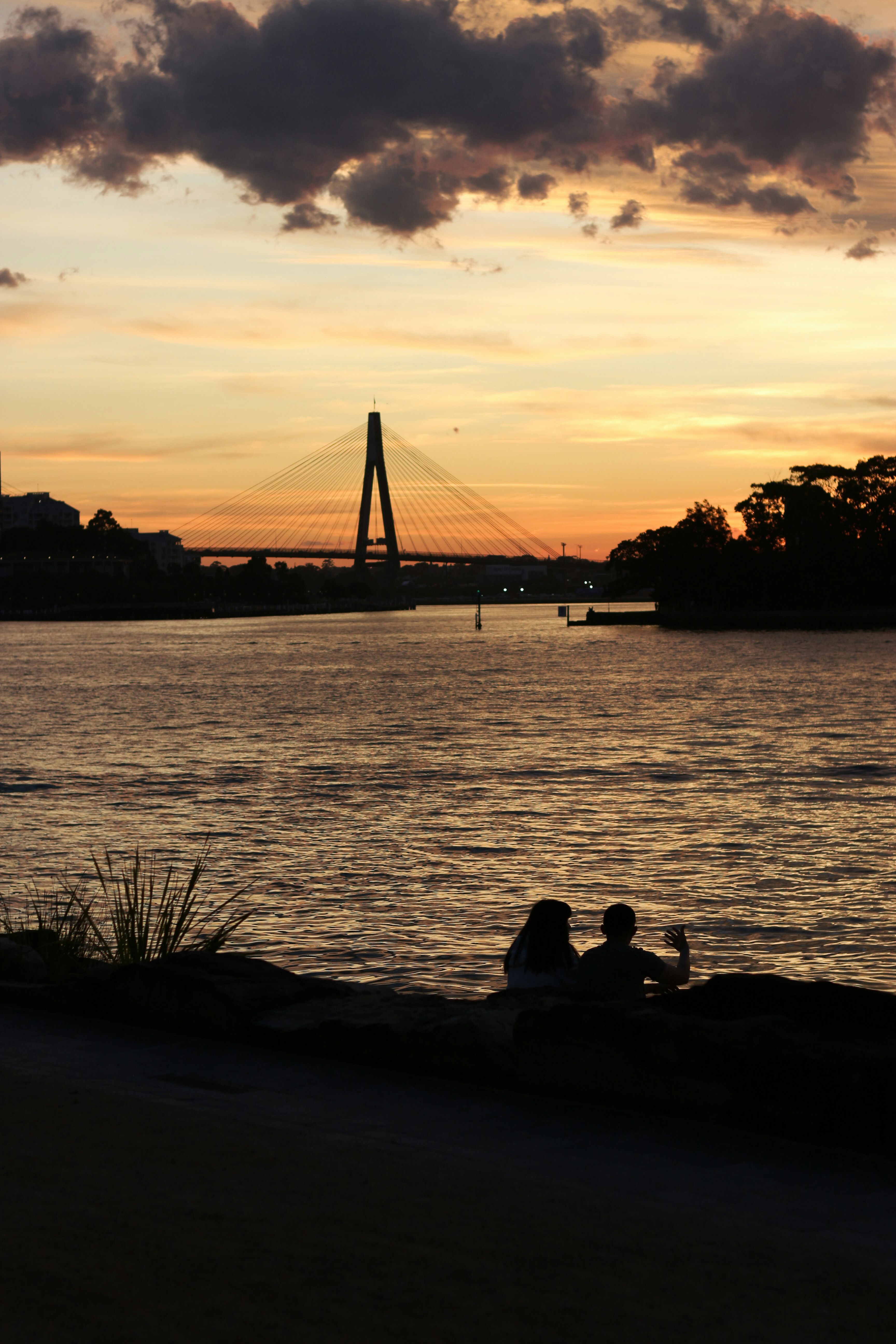 Silhouetted Couple by the Riverside at Golden Hour
