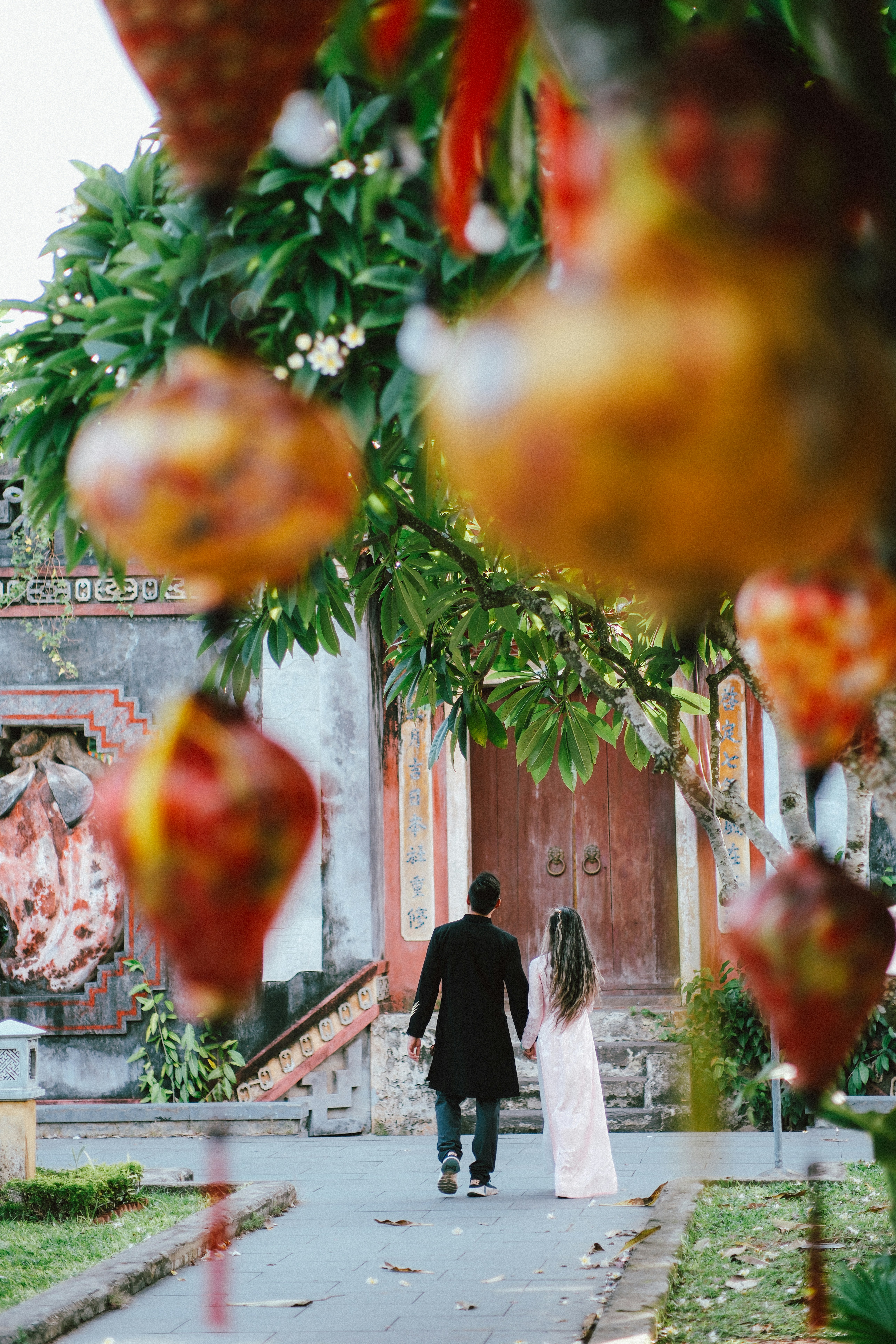 Couple Walking Toward a Timeless Portal Framed by Hanging Orbs