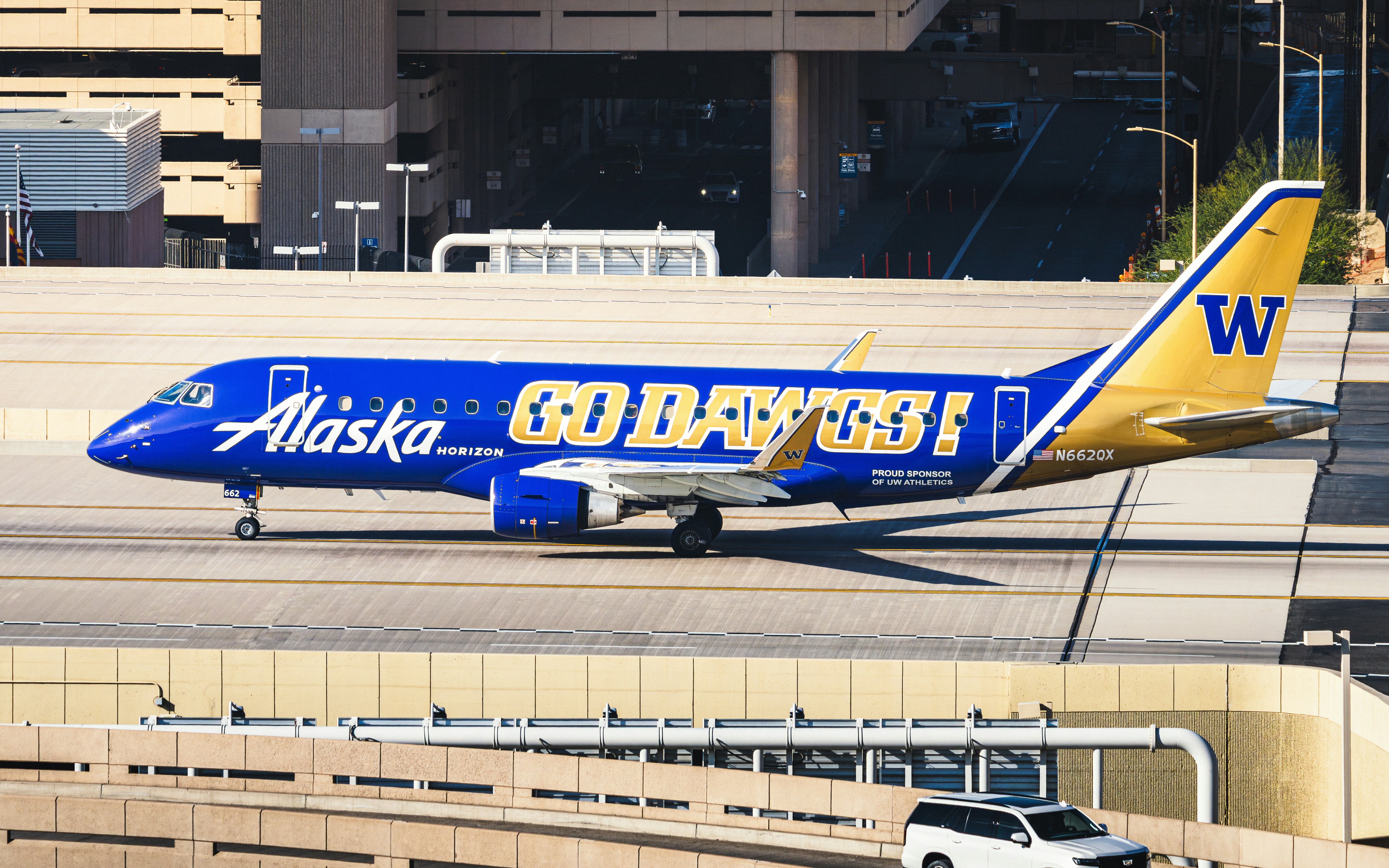 Alaska Airlines "Go Dawgs" E175 crossing the taxiway bridge at Phoenix Sky-Harbor Airport from SFO.