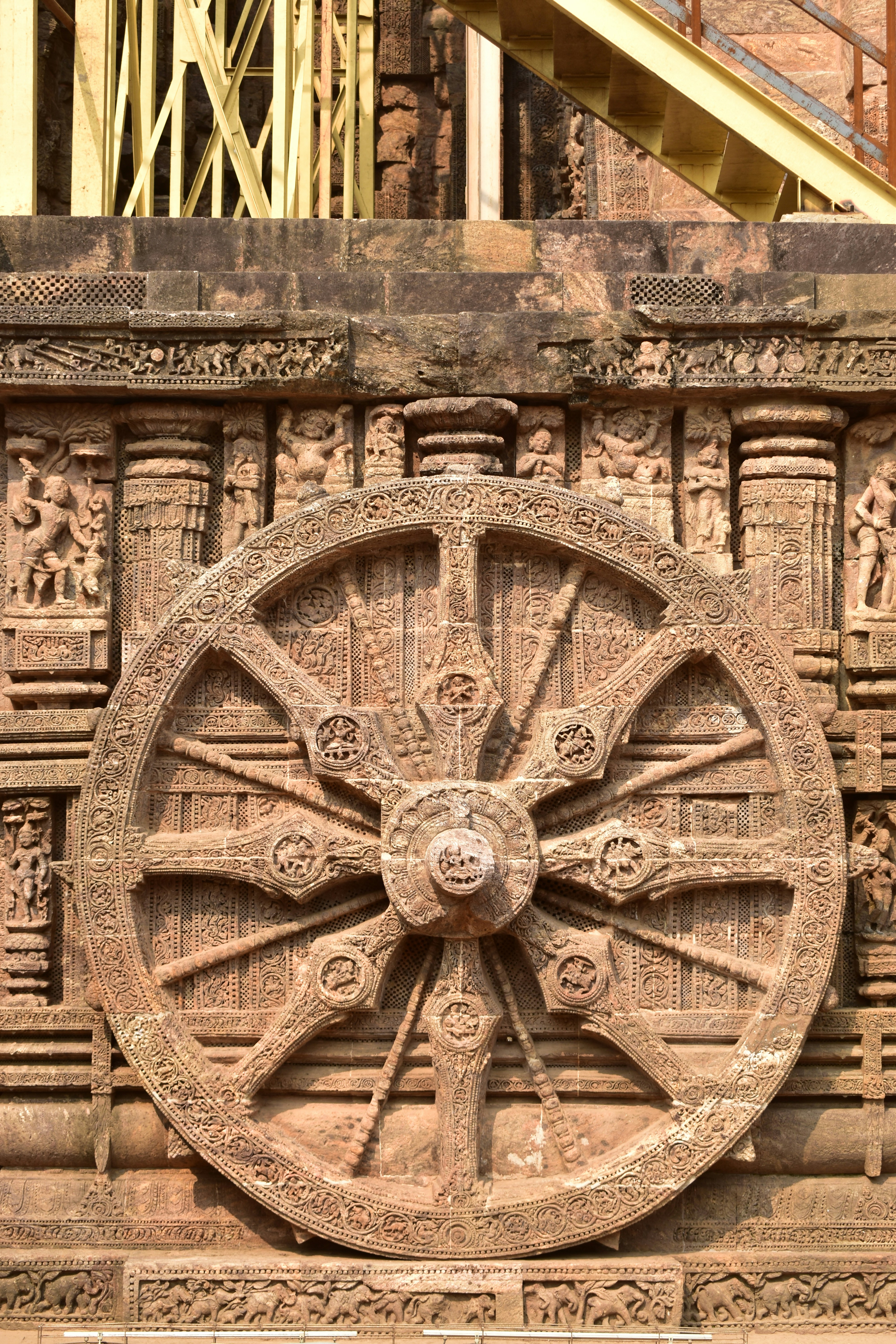 Ancient Wheel Carved in Stone: A Circular Relic Framed by Ornate Reliefs