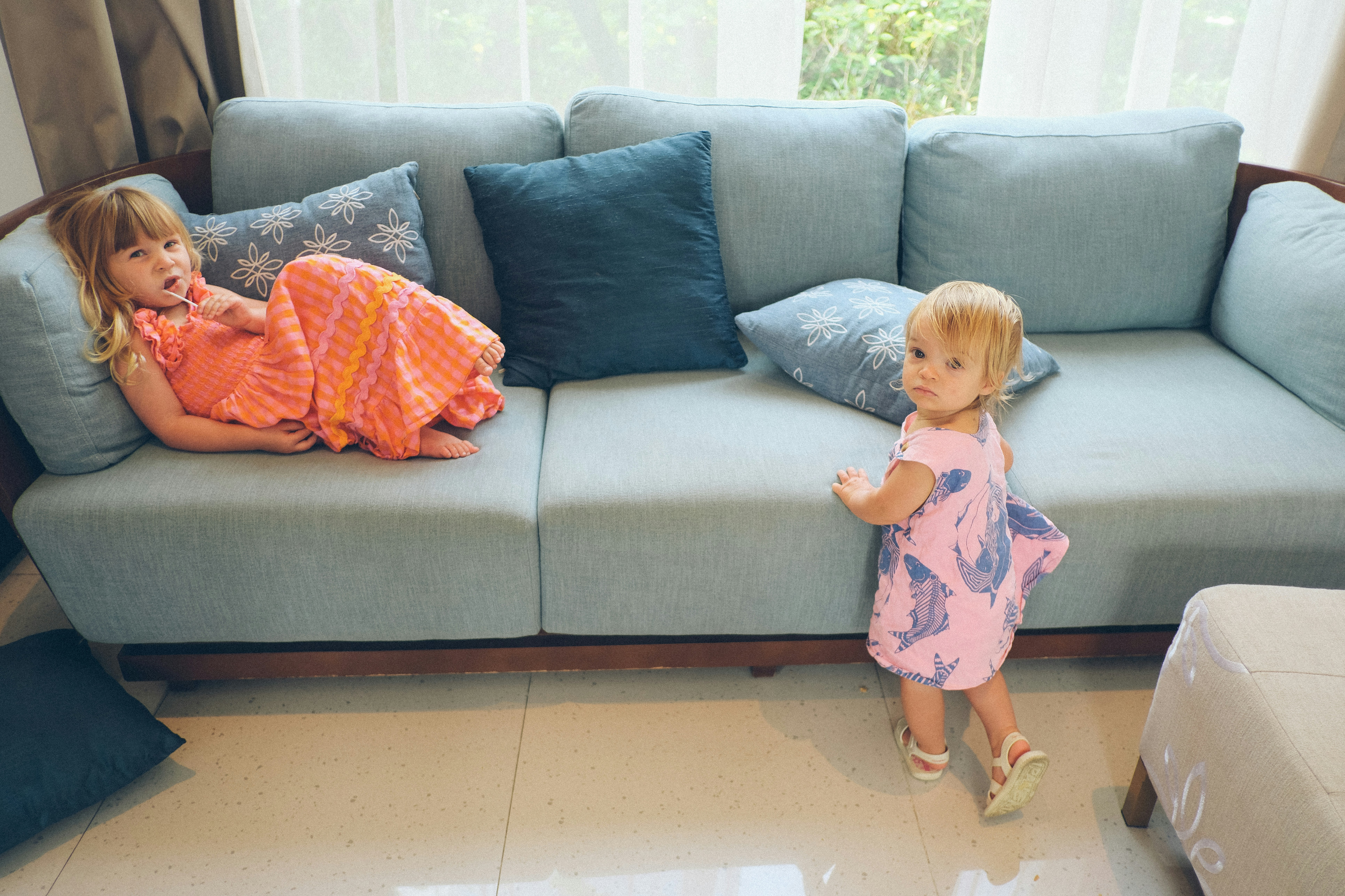Two young girls on a light blue sofa