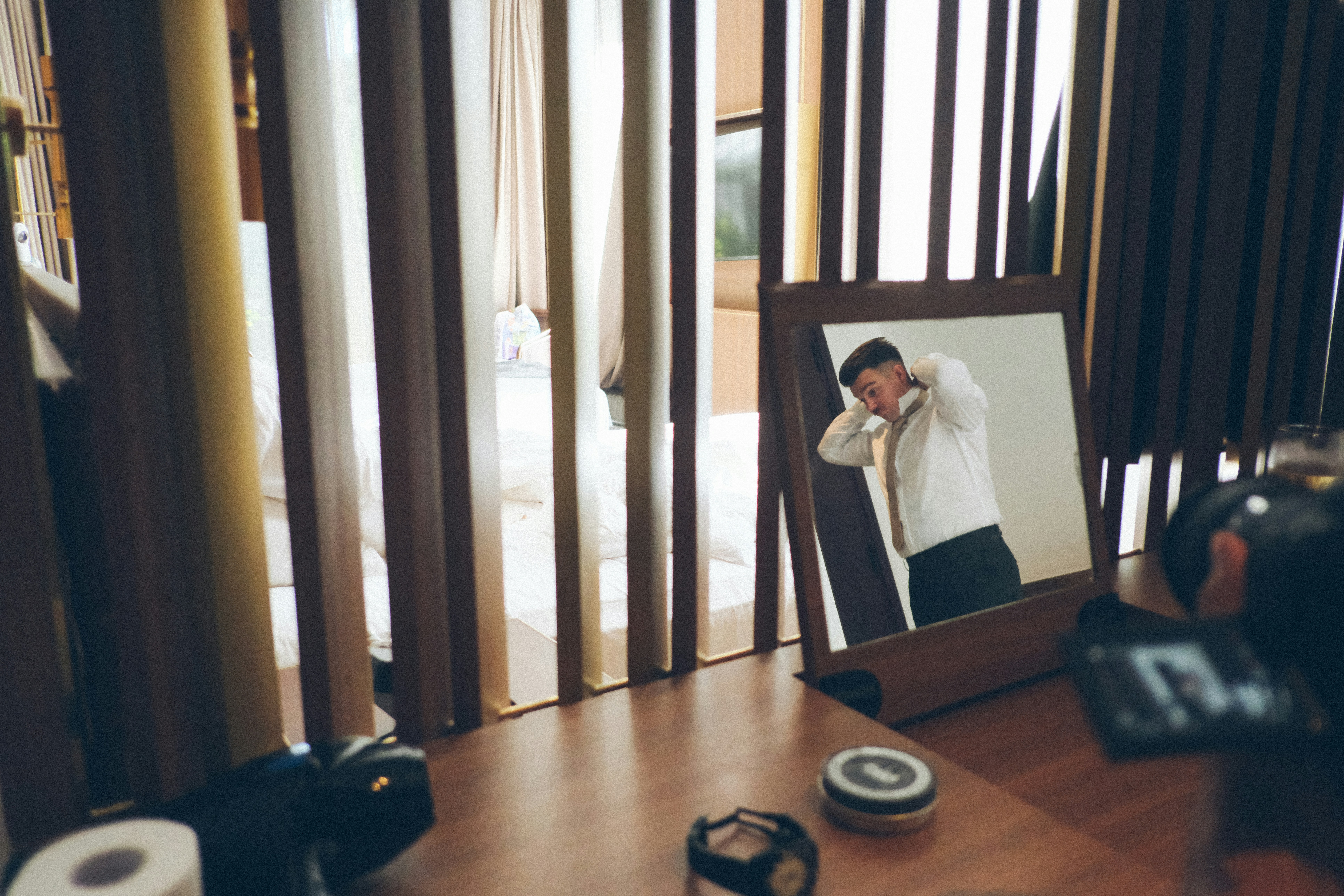 Man adjusting collar in mirror reflection