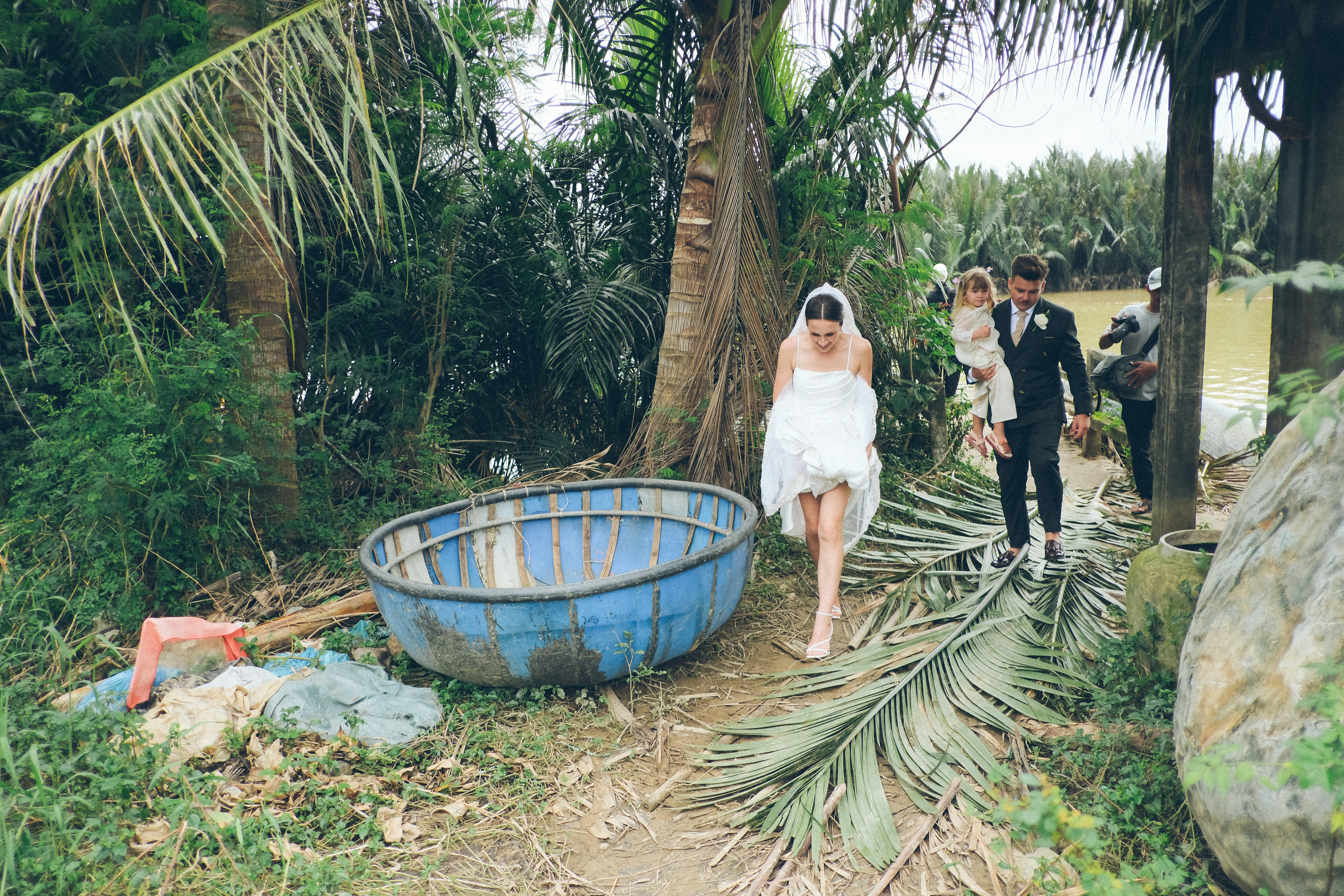 Barefoot Exit: Bride Leads the Way Through Tropical Debris