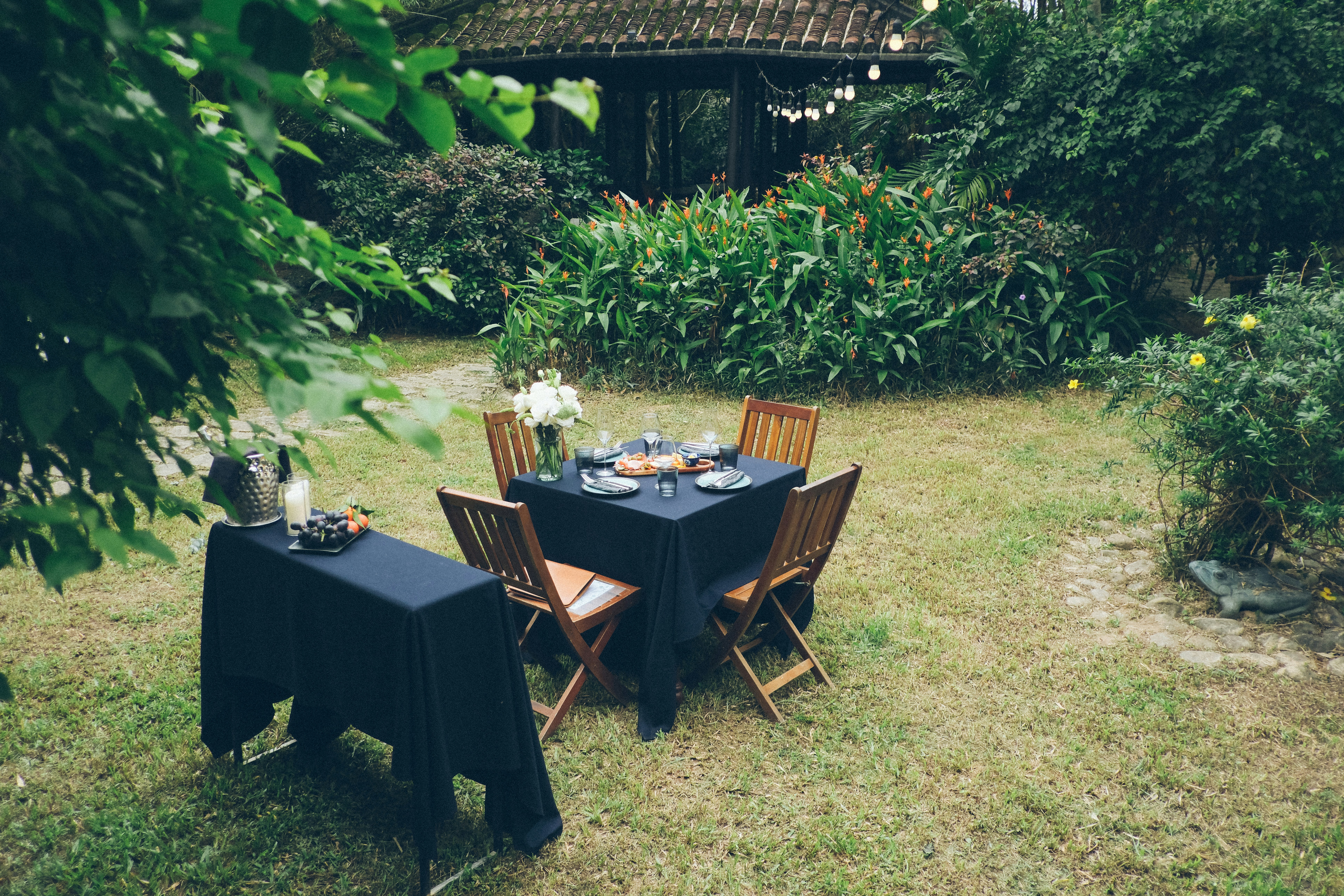 A table set for dinner in a lush garden.