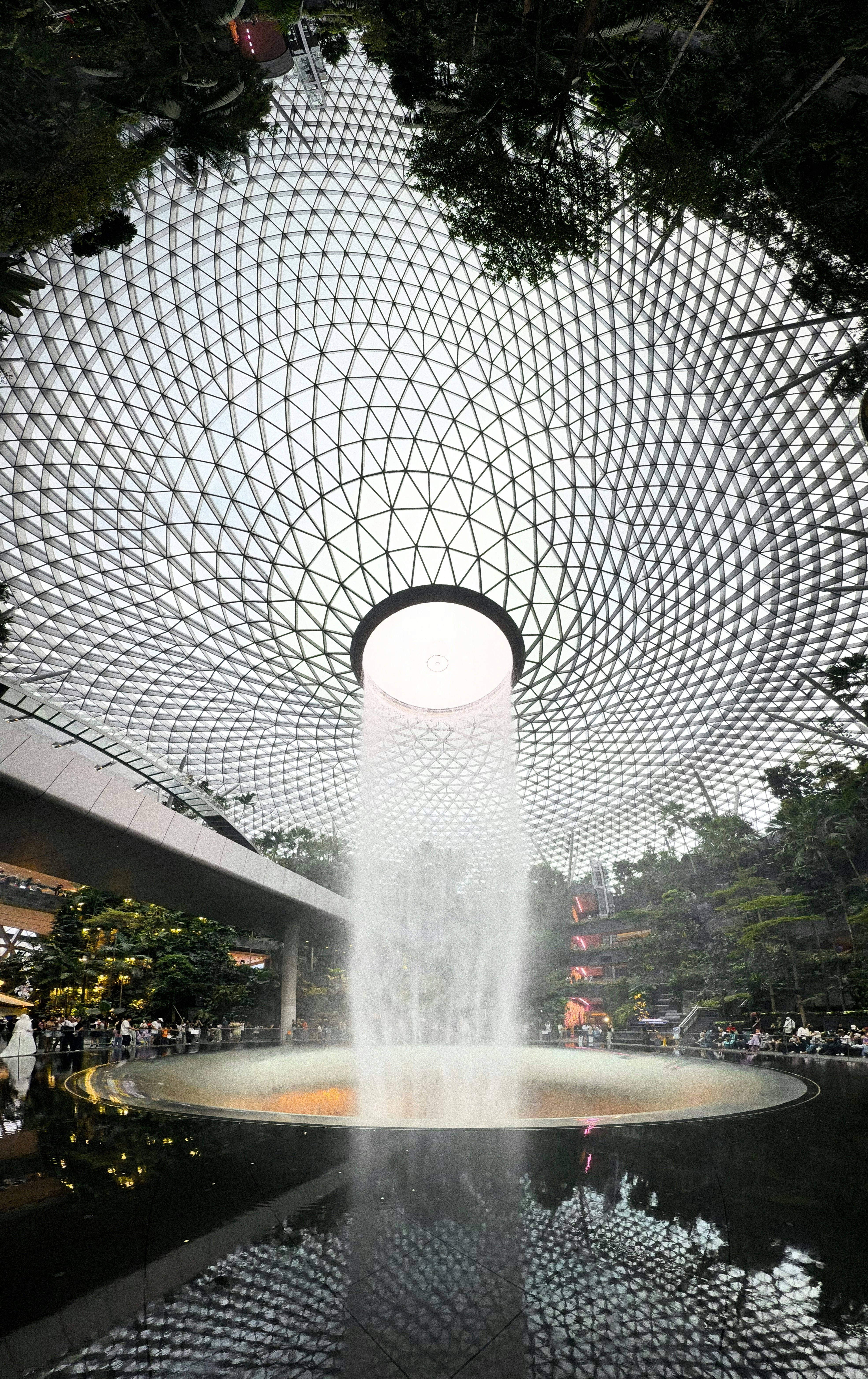 A series captured inside Jewel Changi Airport, featuring the Rain Vortex surrounded by a vast glass dome and indoor forest. Water cascades through the geometric ceiling while greenery and reflections soften the monumental scale. The contrast between structure, nature, and motion creates a calm yet immersive atmosphere within one of the world’s busiest airports.