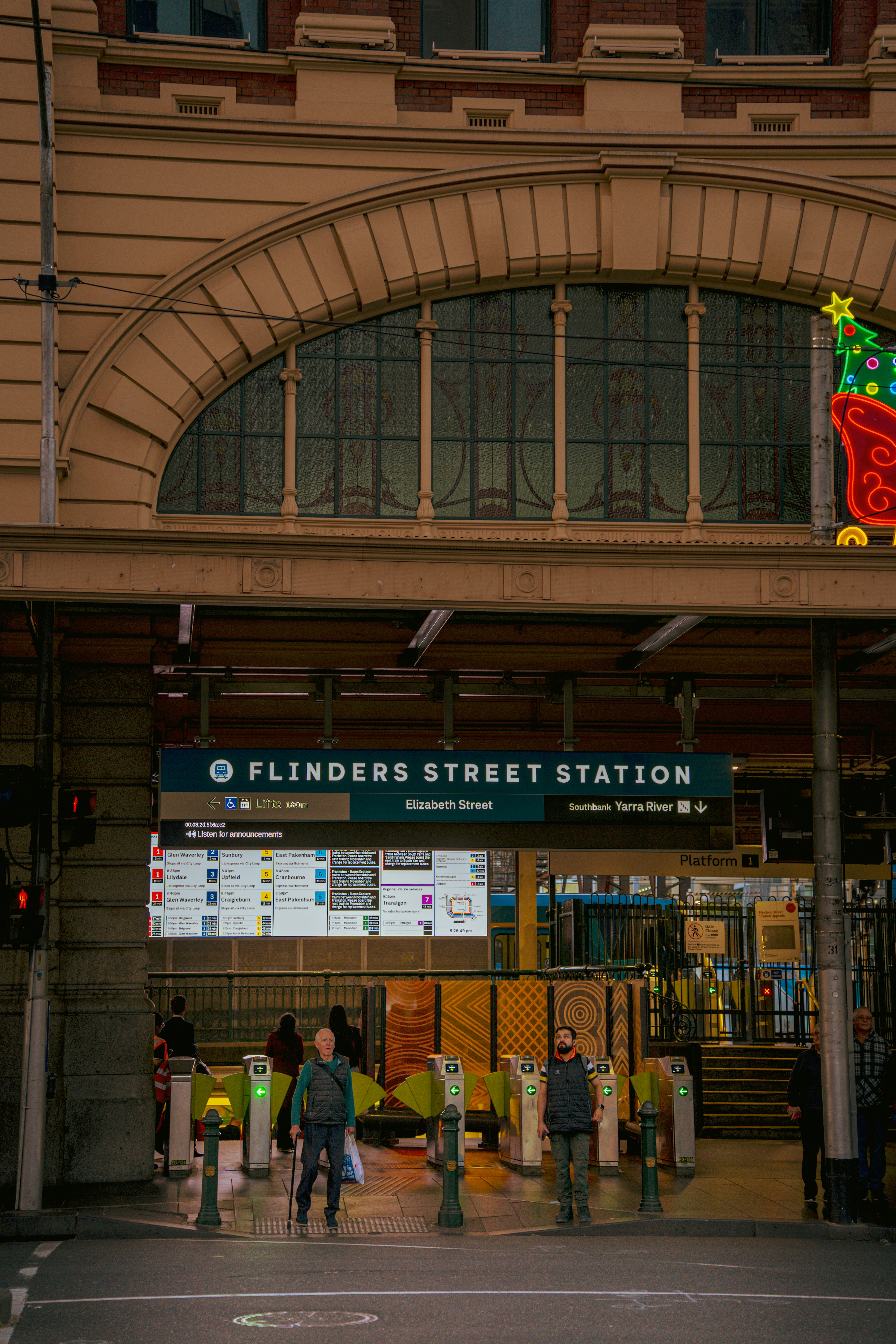Flinders Street Entrance: People and Gates Under the Arch