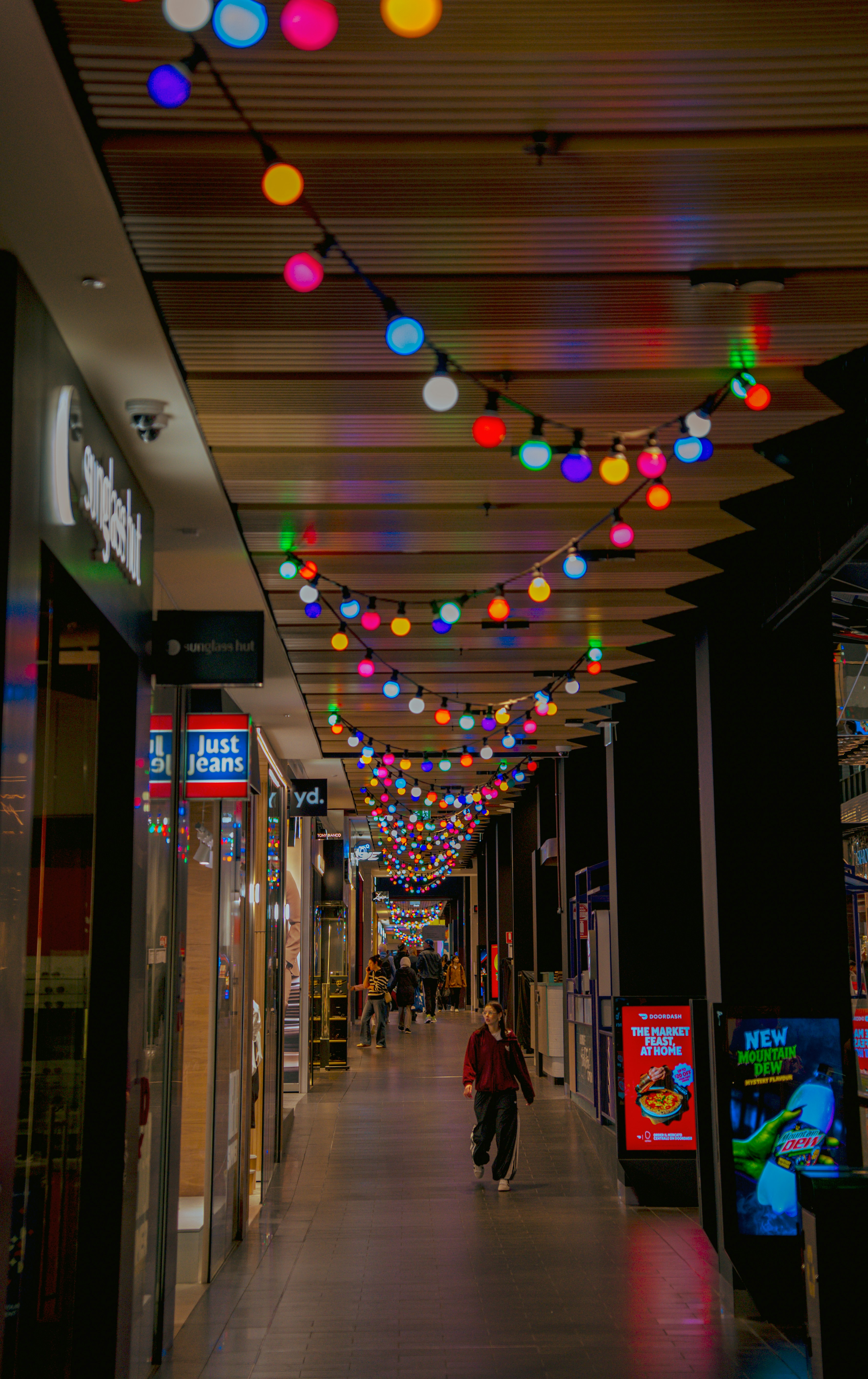 Busy street scene in Melbourne CBD bathed in golden hour light. Pedestrians crossing the road with dramatic long shadows and sun rays cutting through the city air