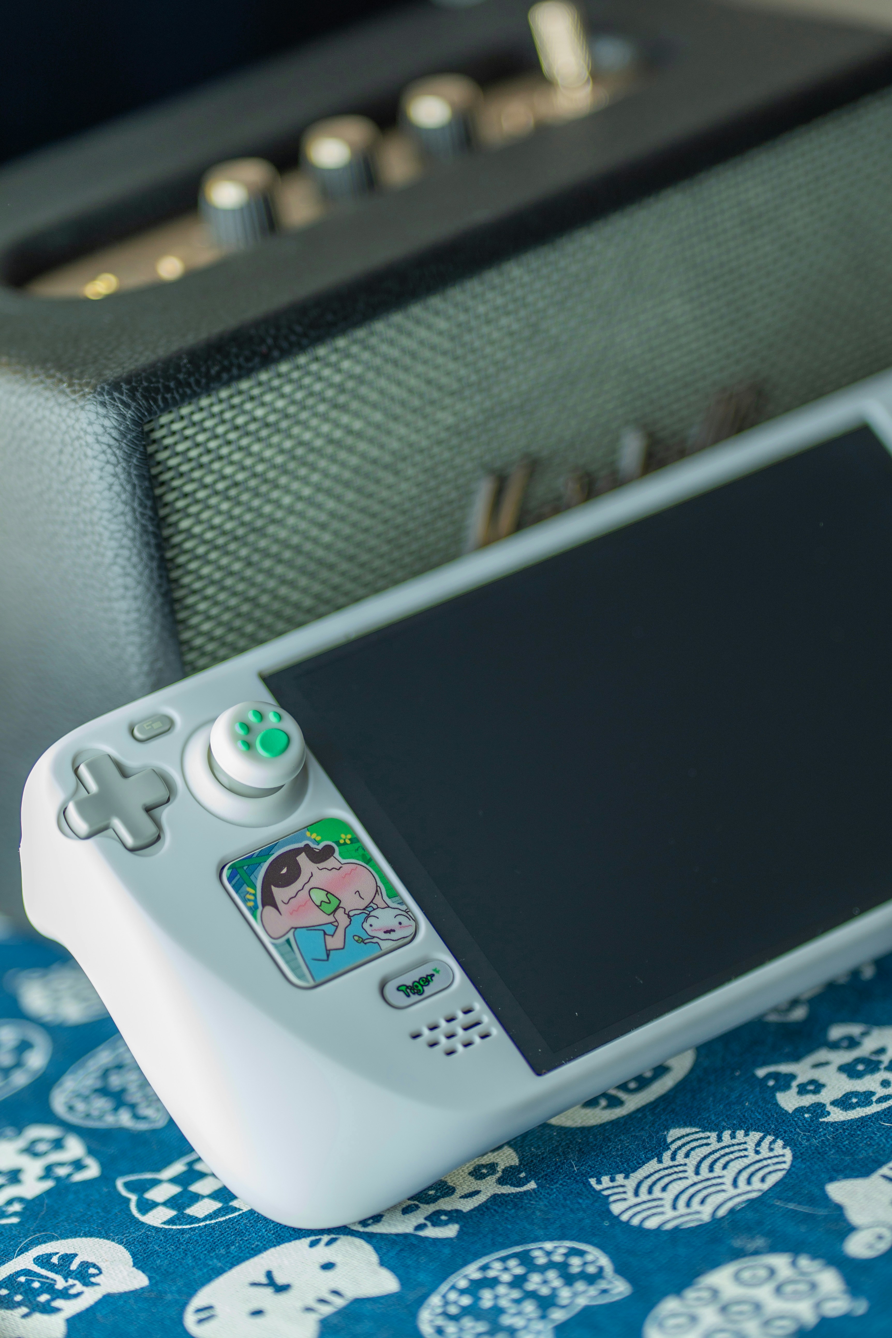 Retro in Your Hands: A Playful Handheld Console Resting by a Vintage Amplifier