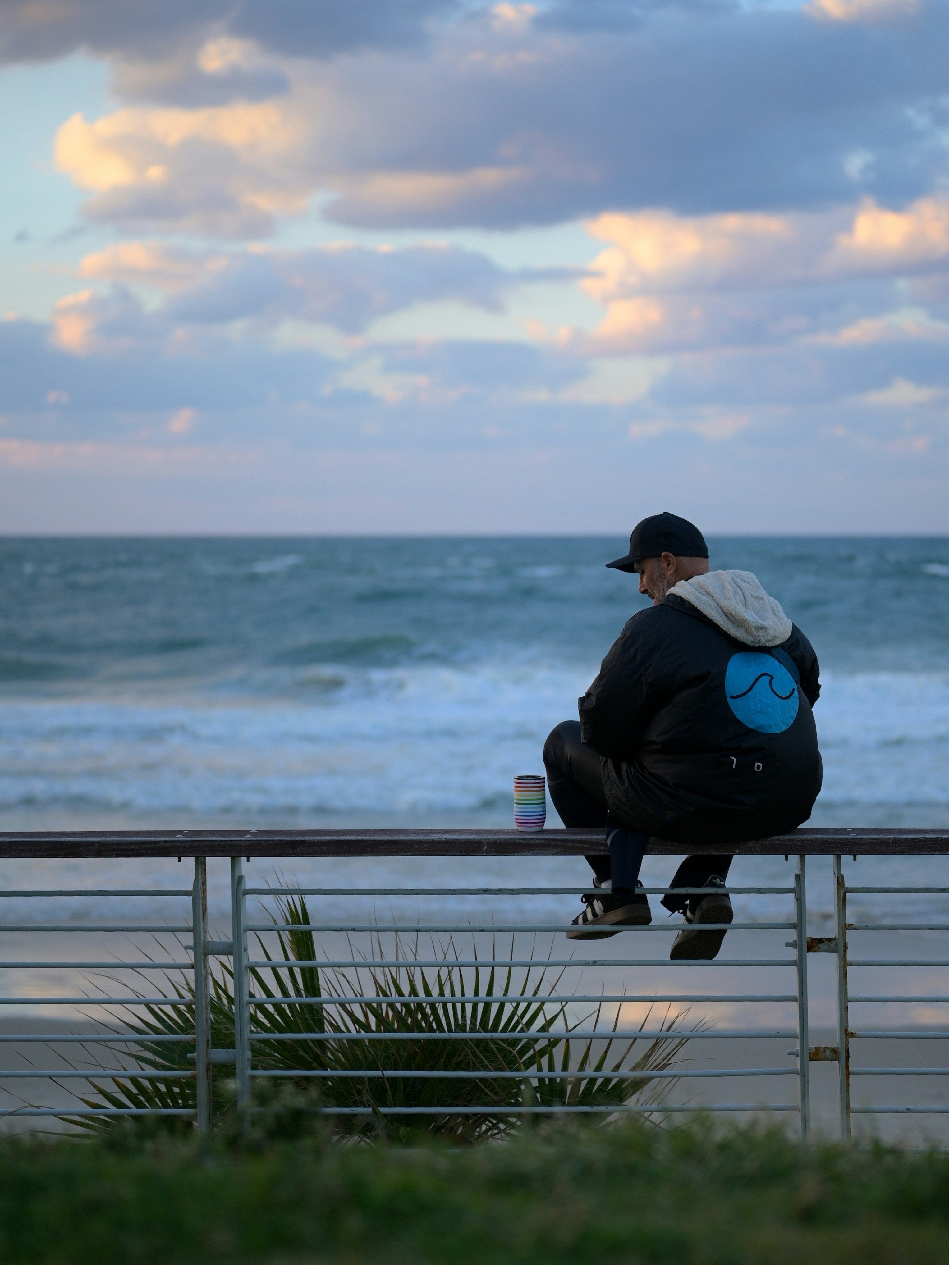 Man sitting on railing overlooking ocean waves photo – Free Travel ...