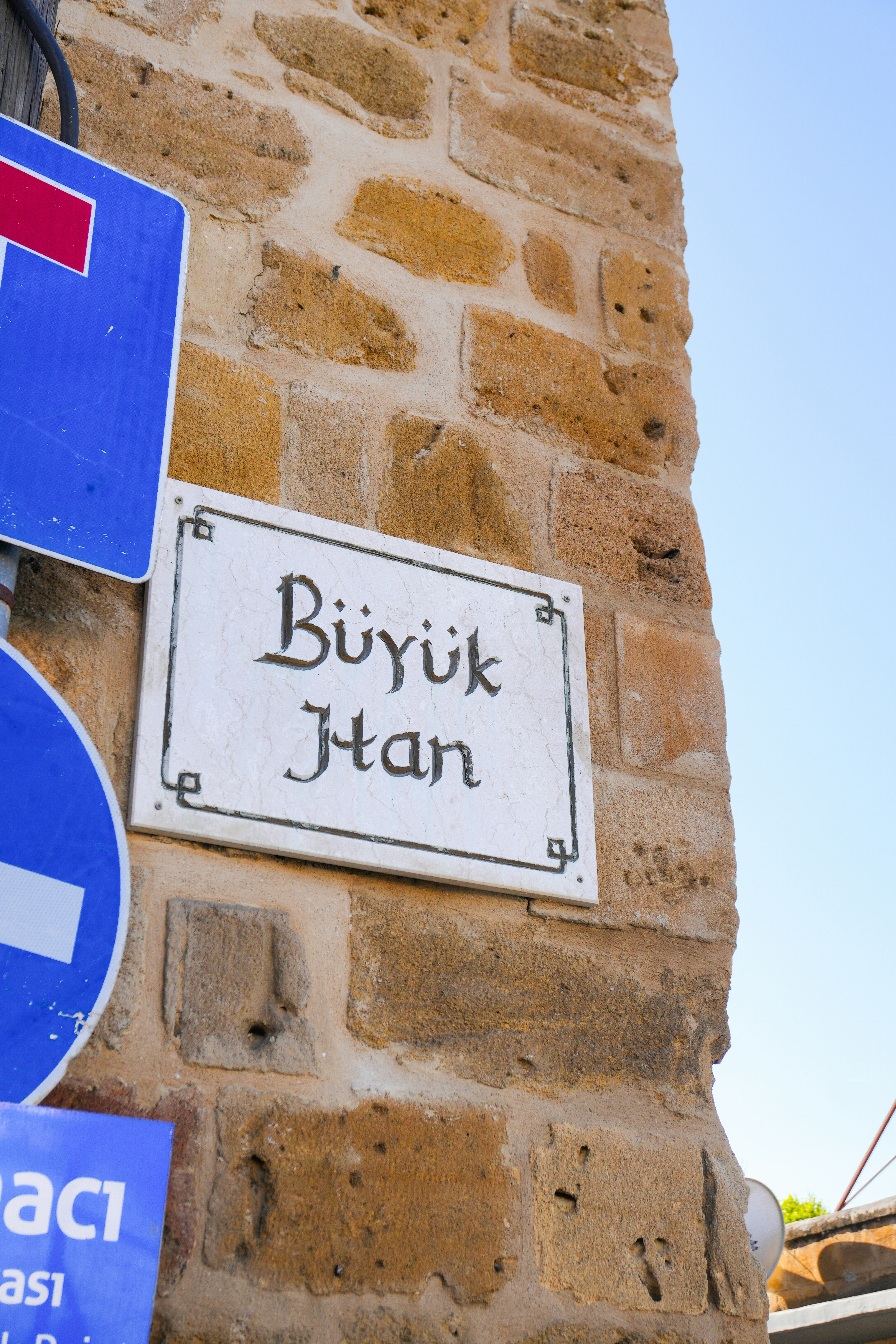 Büyük Han Stone Plaque on Sunlit Brick Corner