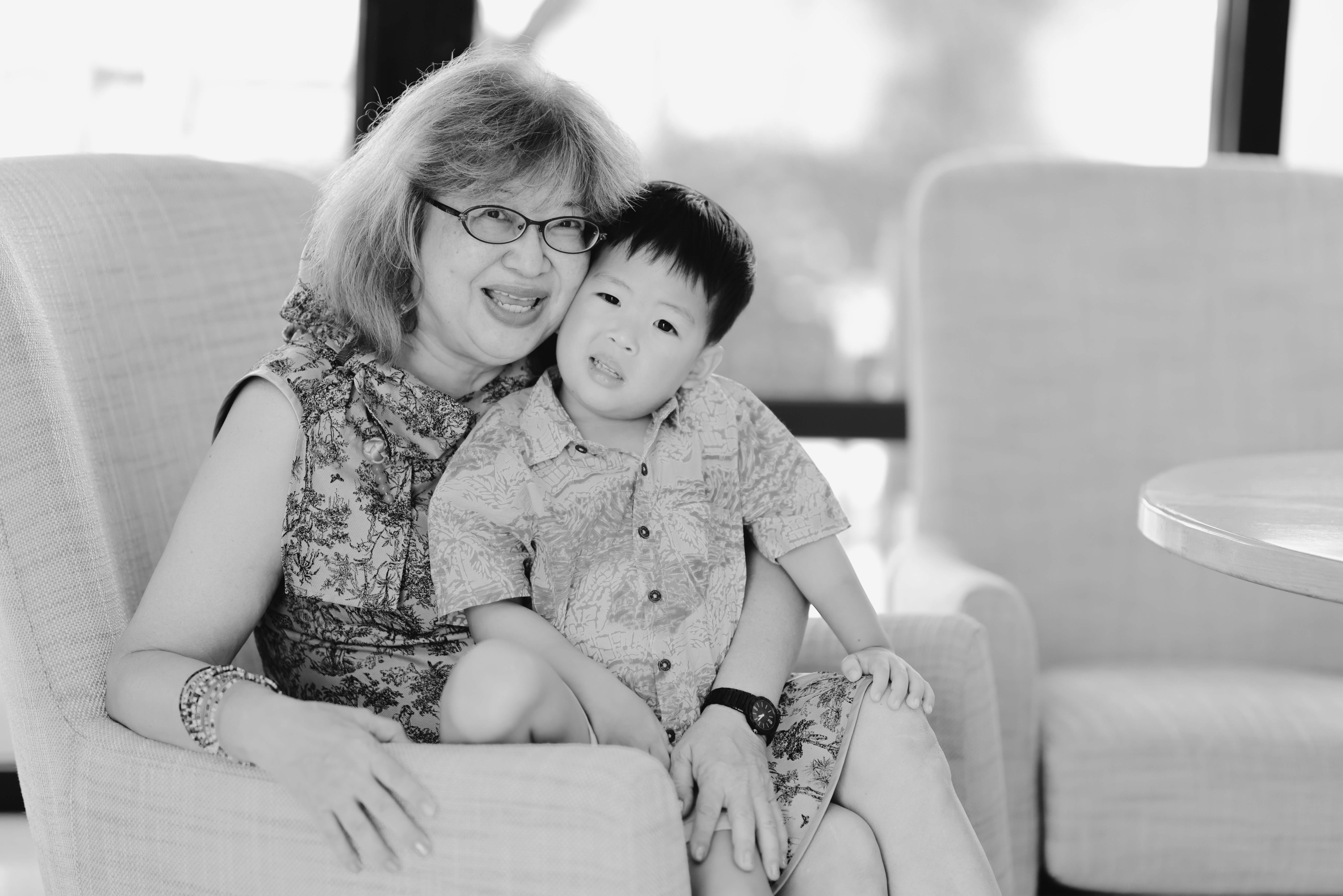 Shared Smile: Grandmother and Grandchild Embrace on a Cozy Sofa