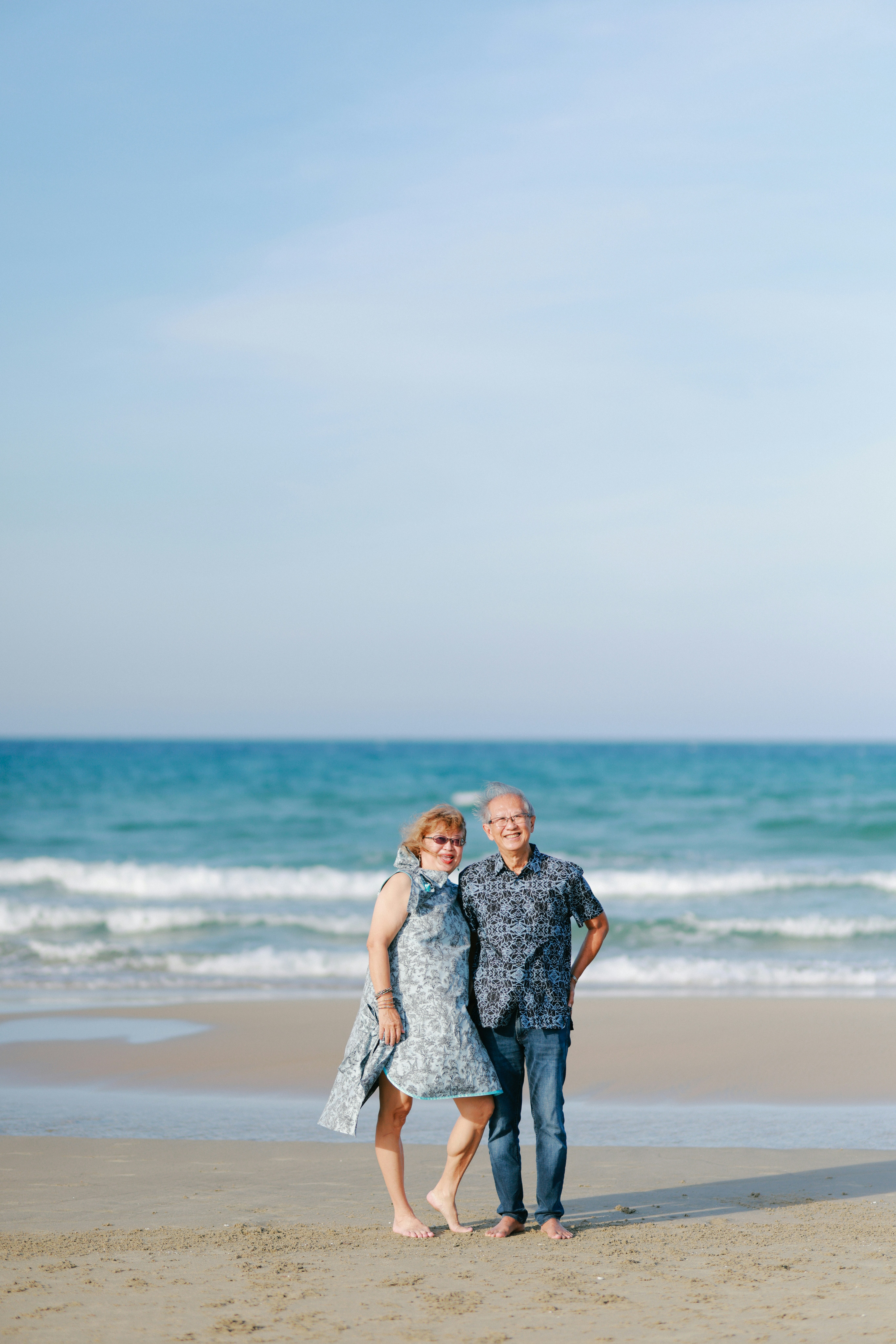 Sunlit Coastal Companions: An Elderly Couple Embracing the Sea