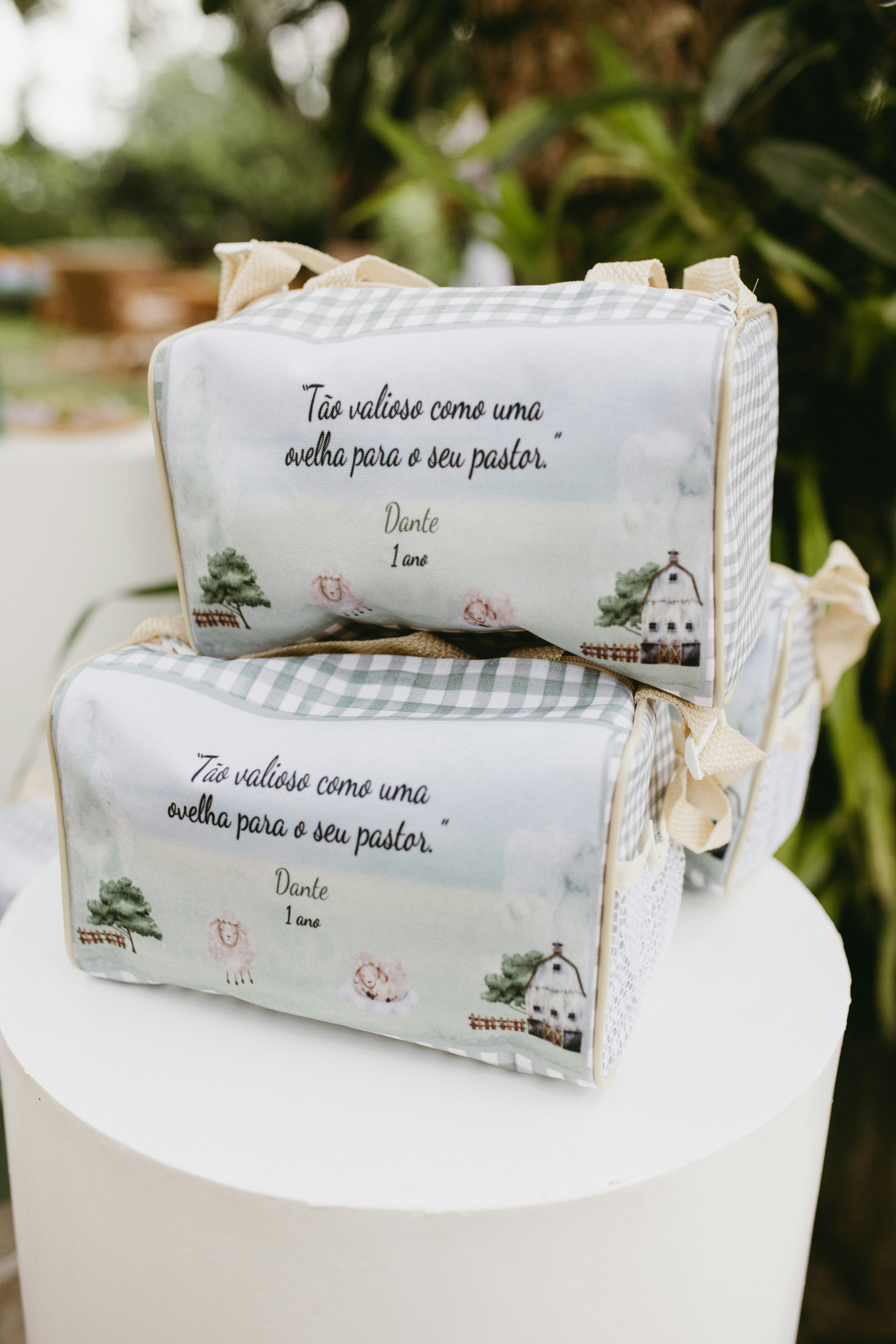 Pastel Wrapped Delights: Stacked Favor Bags on a White Pedestal