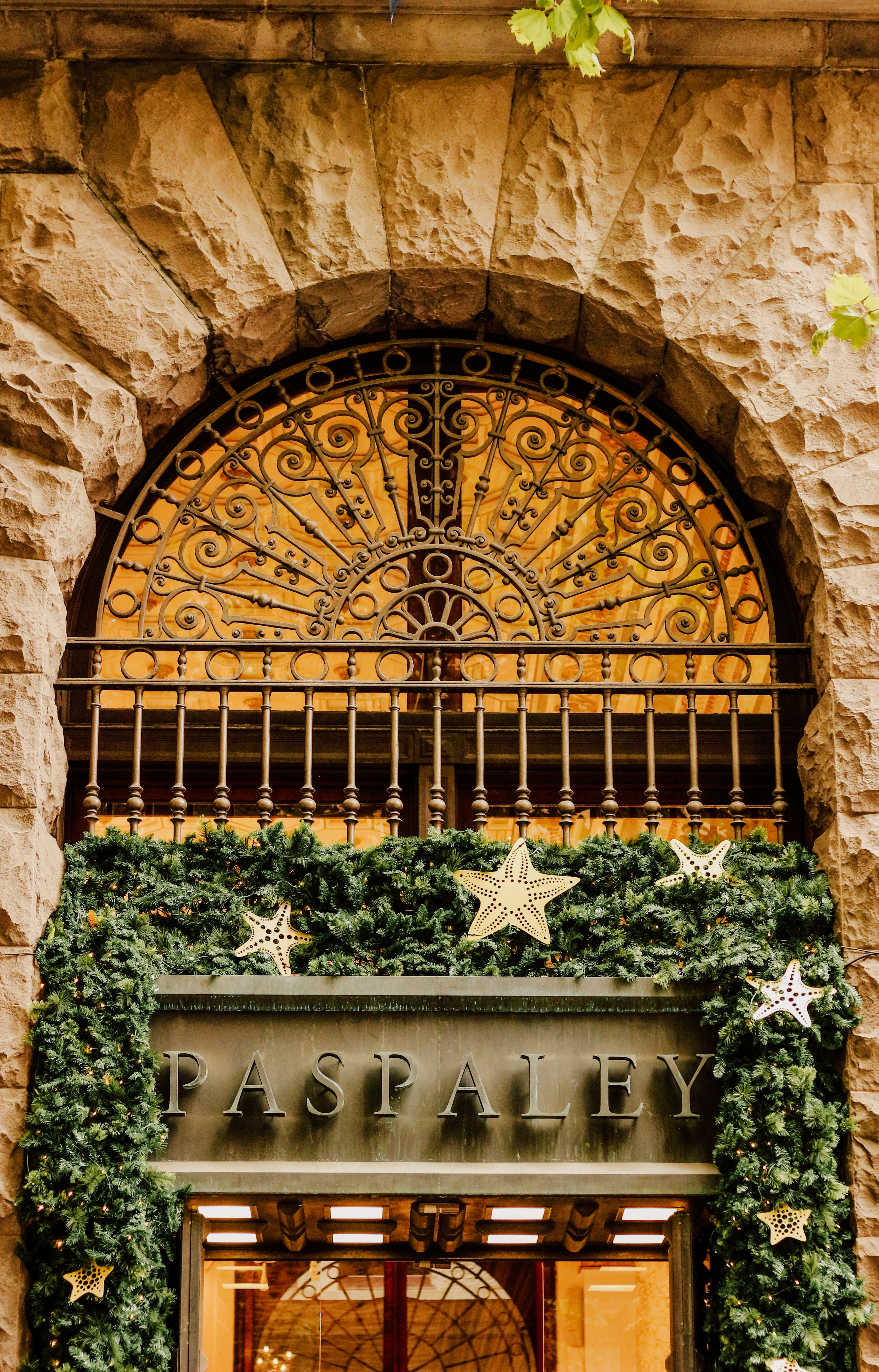 Arched Ornament Over a Green-Wrapped Storefront Sign