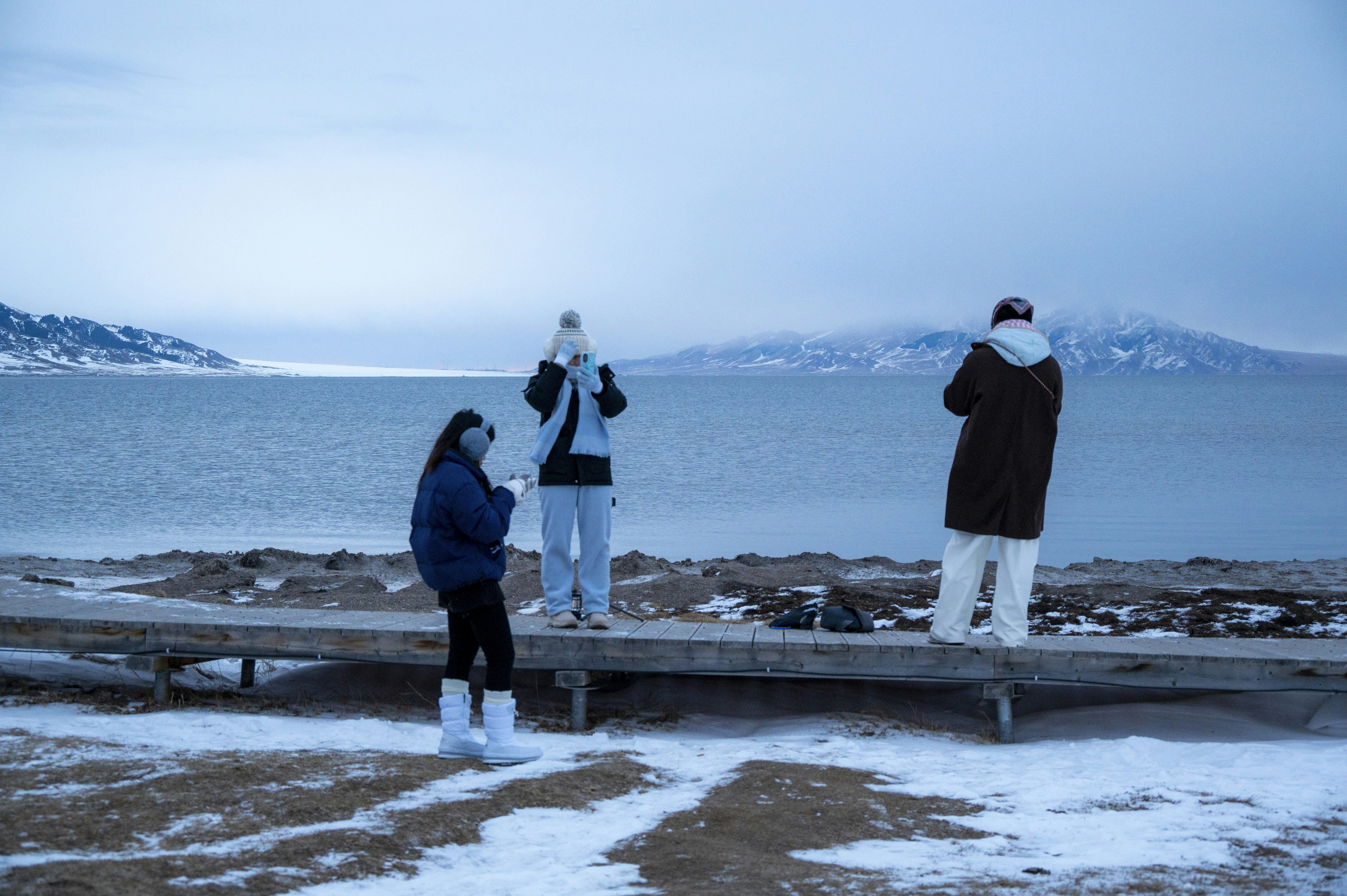 Three Figures on a Snowy Shore: A Cold Coastal Portrait
