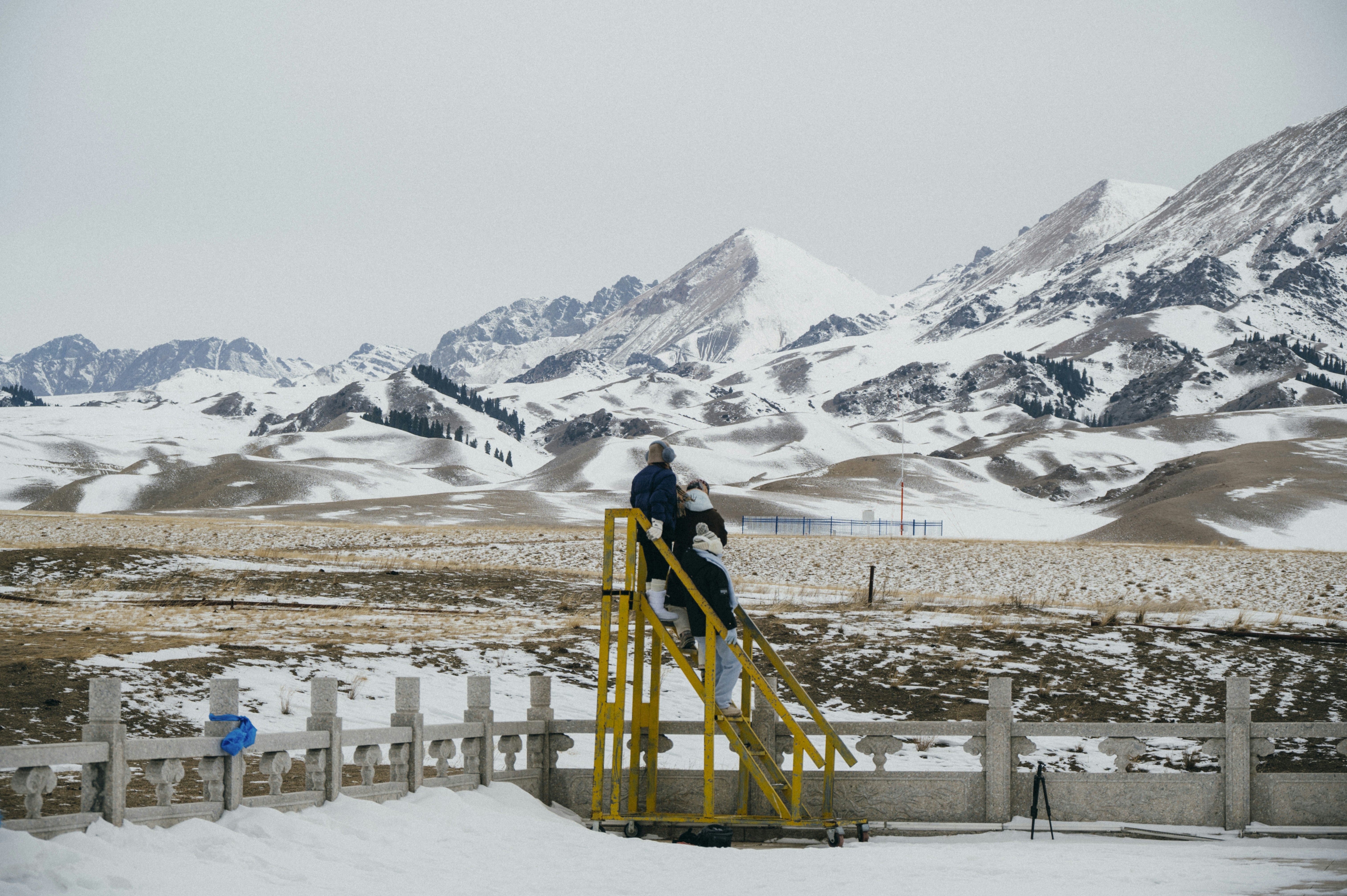 Liftoff on the Snow: A Figure Ascends the Yellow Staircase Against Alpine Vistas