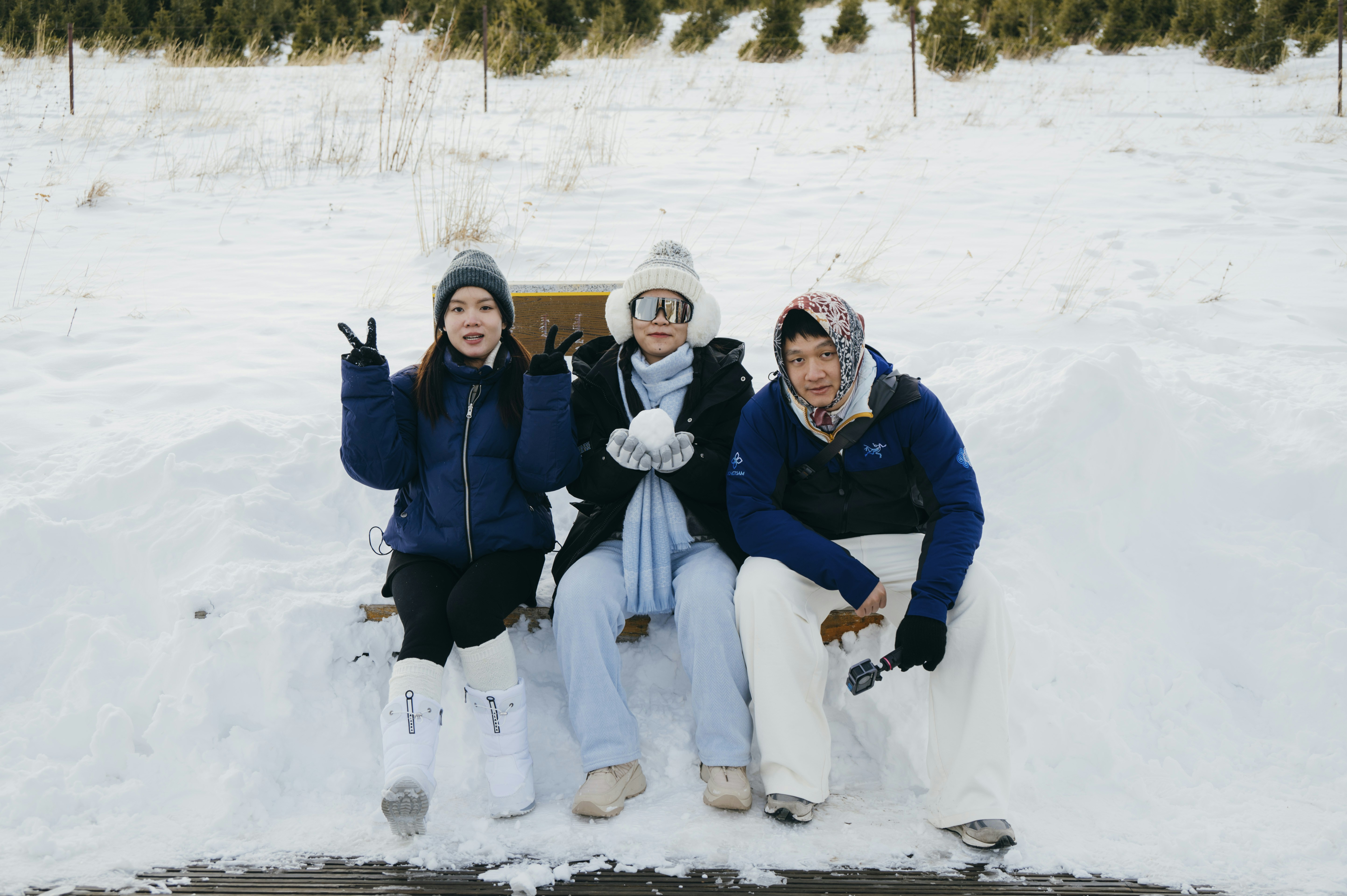 Snowy bench portrait: a trio sharing a winter moment
