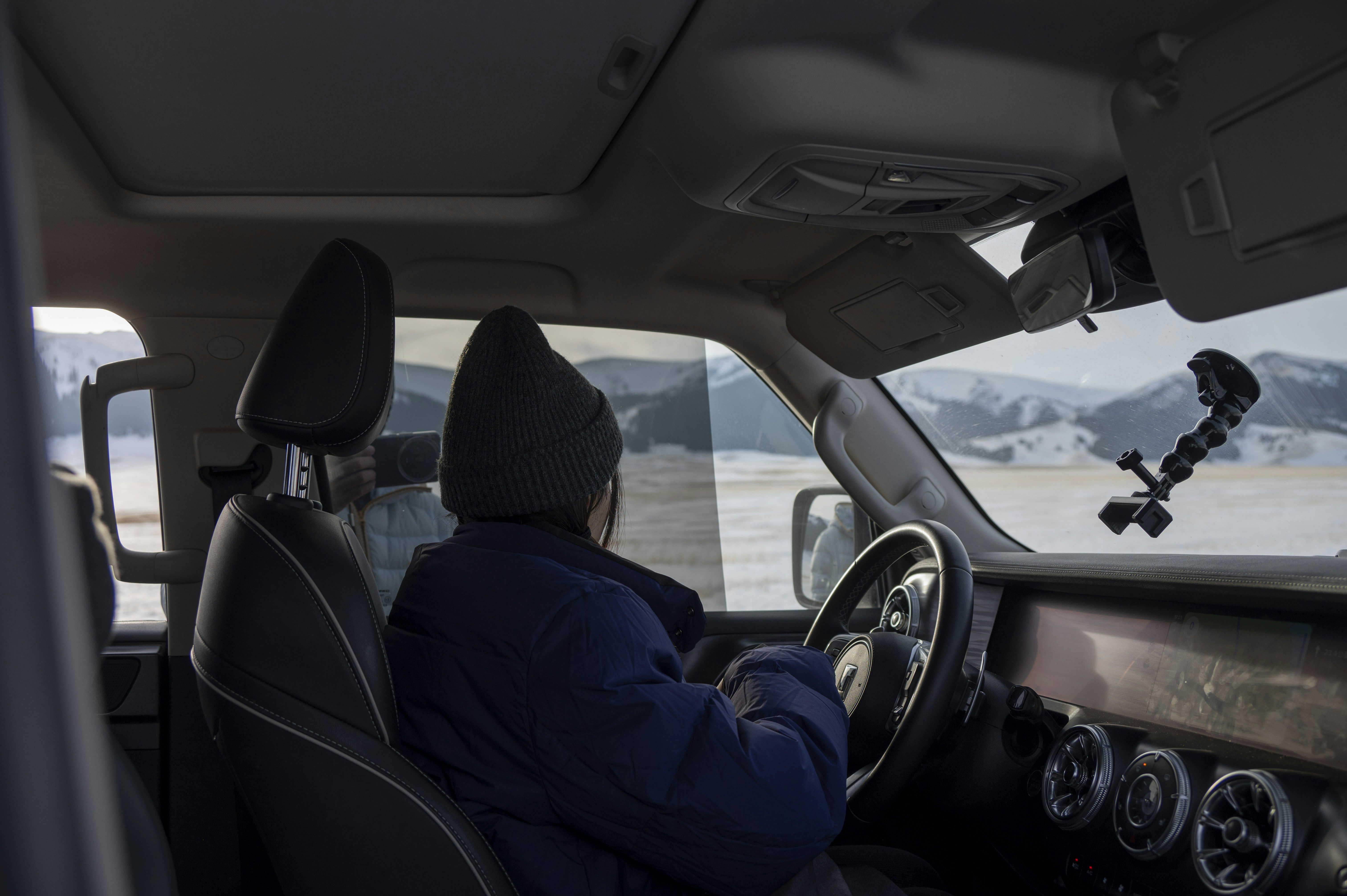 Cozy Winter Drive: A Driver Focused at the Wheel with Snowy Landscape Beyond