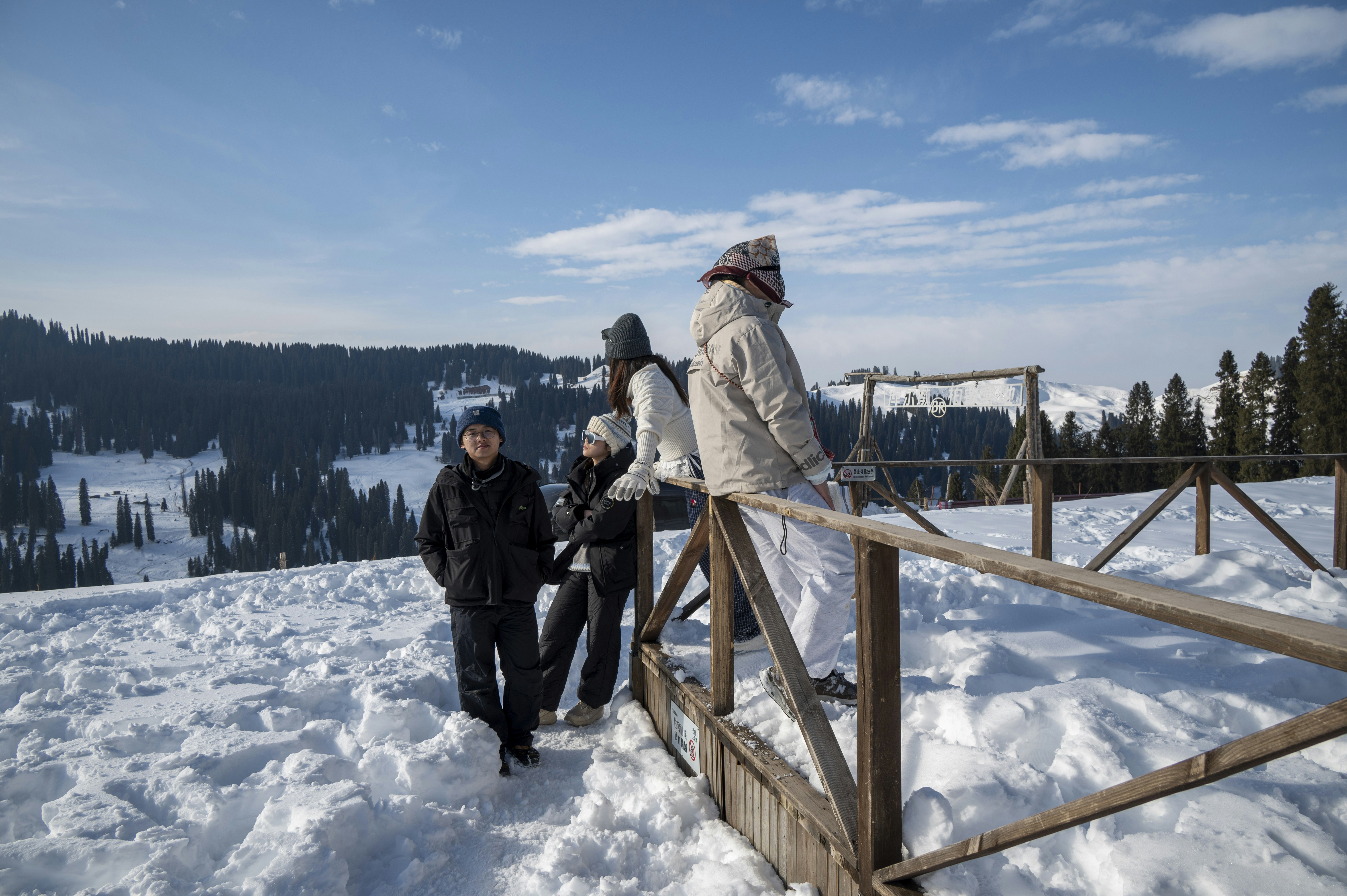 Snowy overlook: a family pause on the wooden railing