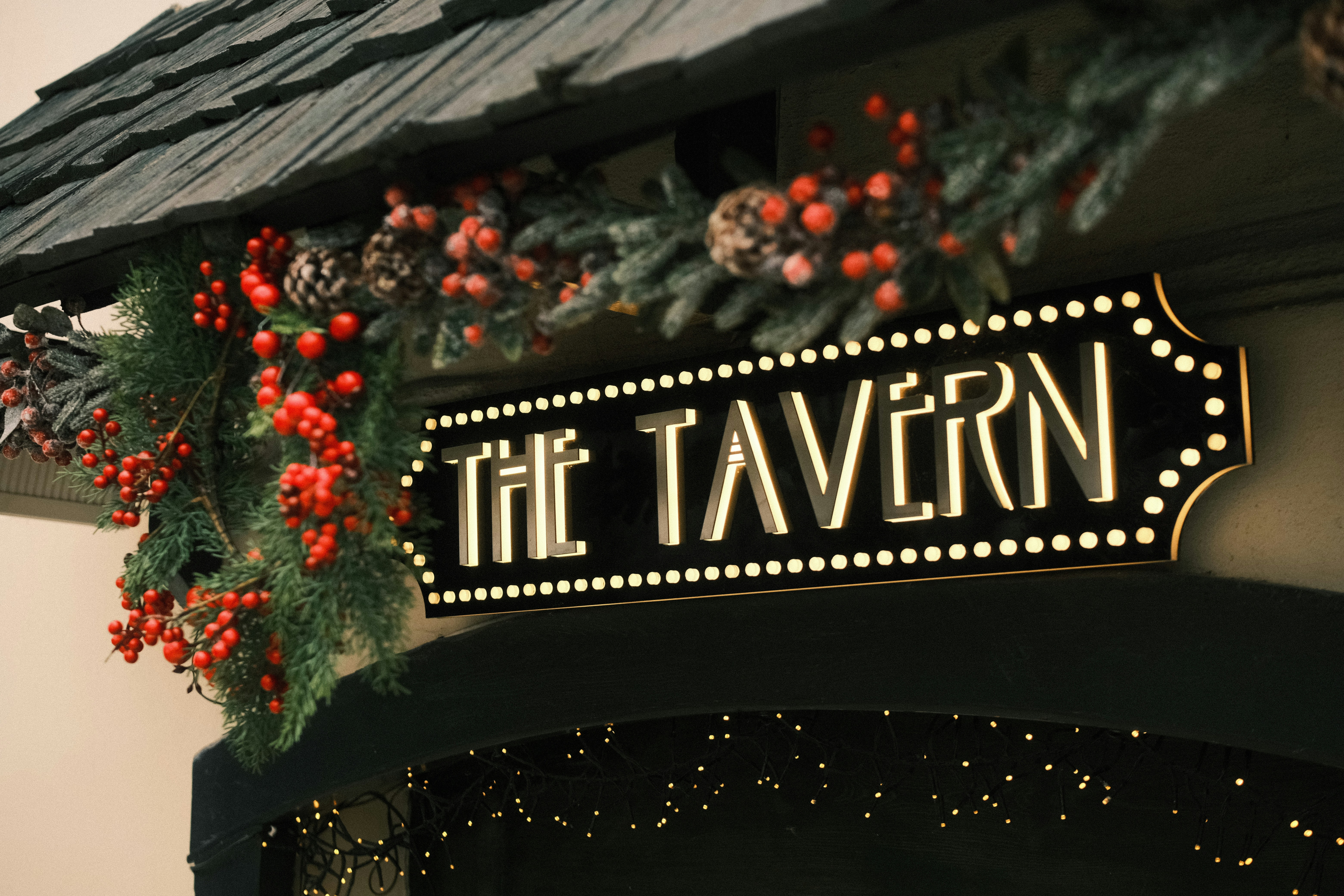 Bright sign above entrance of tavern with decorations
