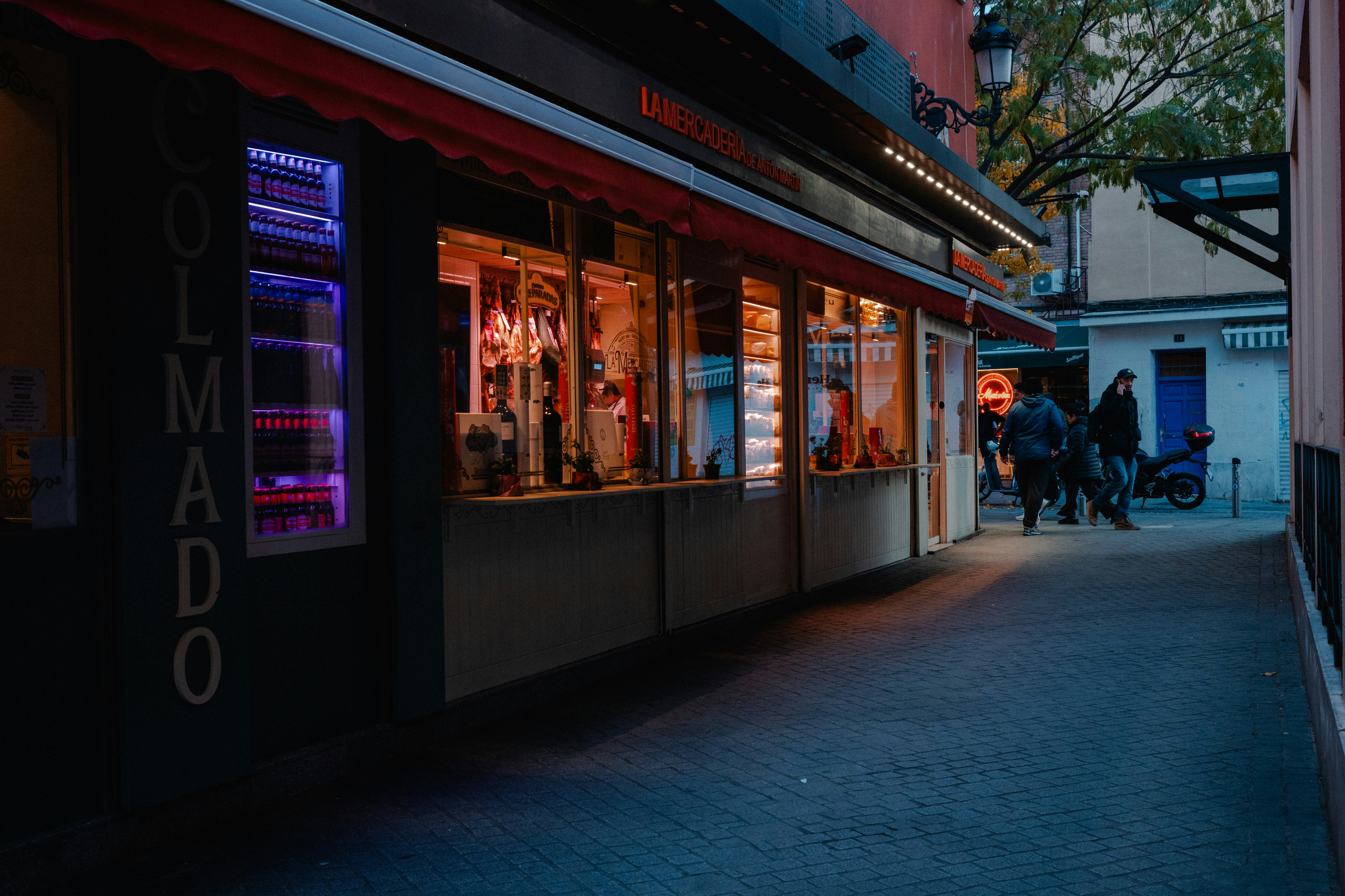 Neon Spillover: Nighttime storefronts and Passing Figures