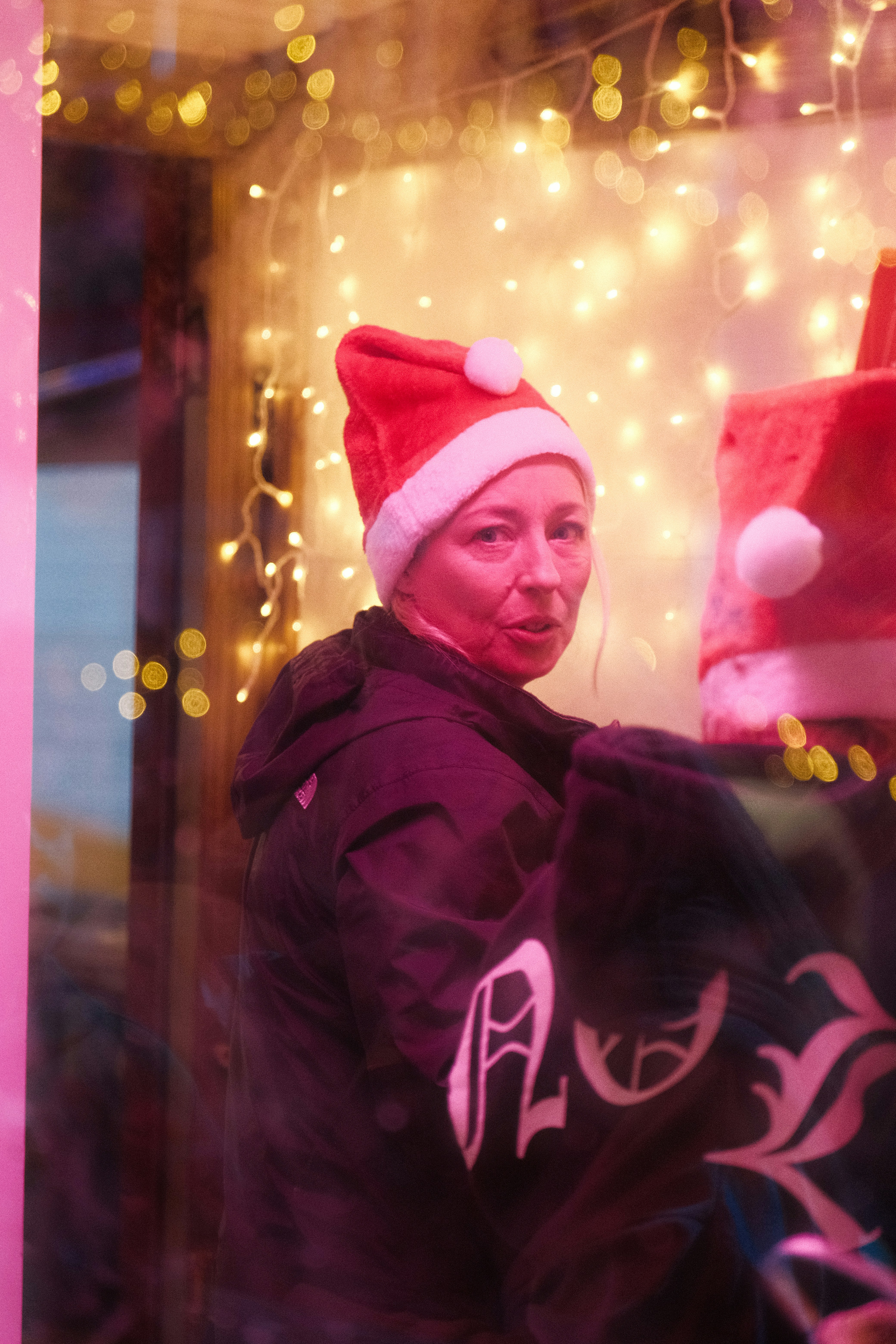 Face in a Festive Glow: Santa Hats and Warm Lights
