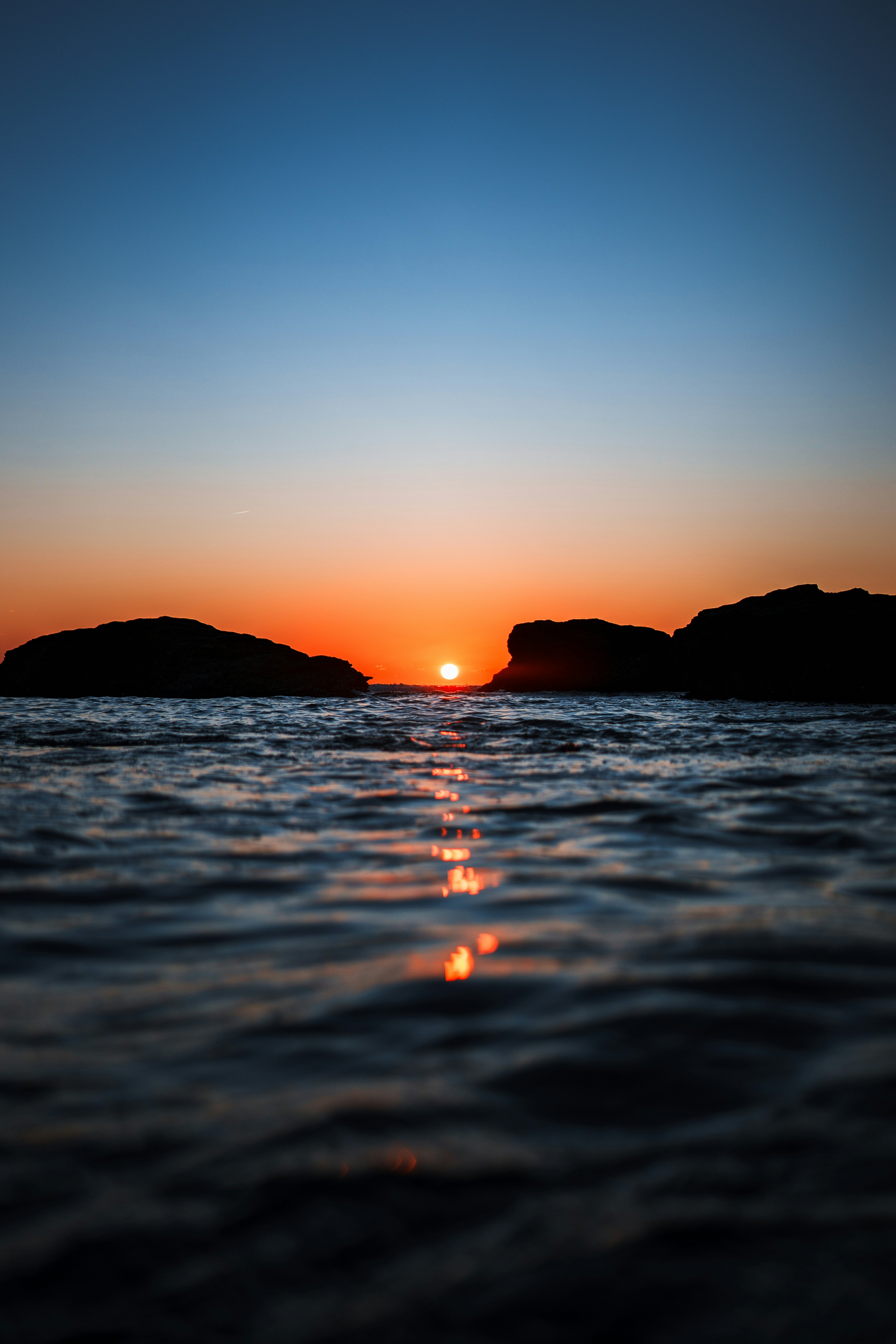 Sunlit Passage: A Quiet Dusk Between Dark Rocks