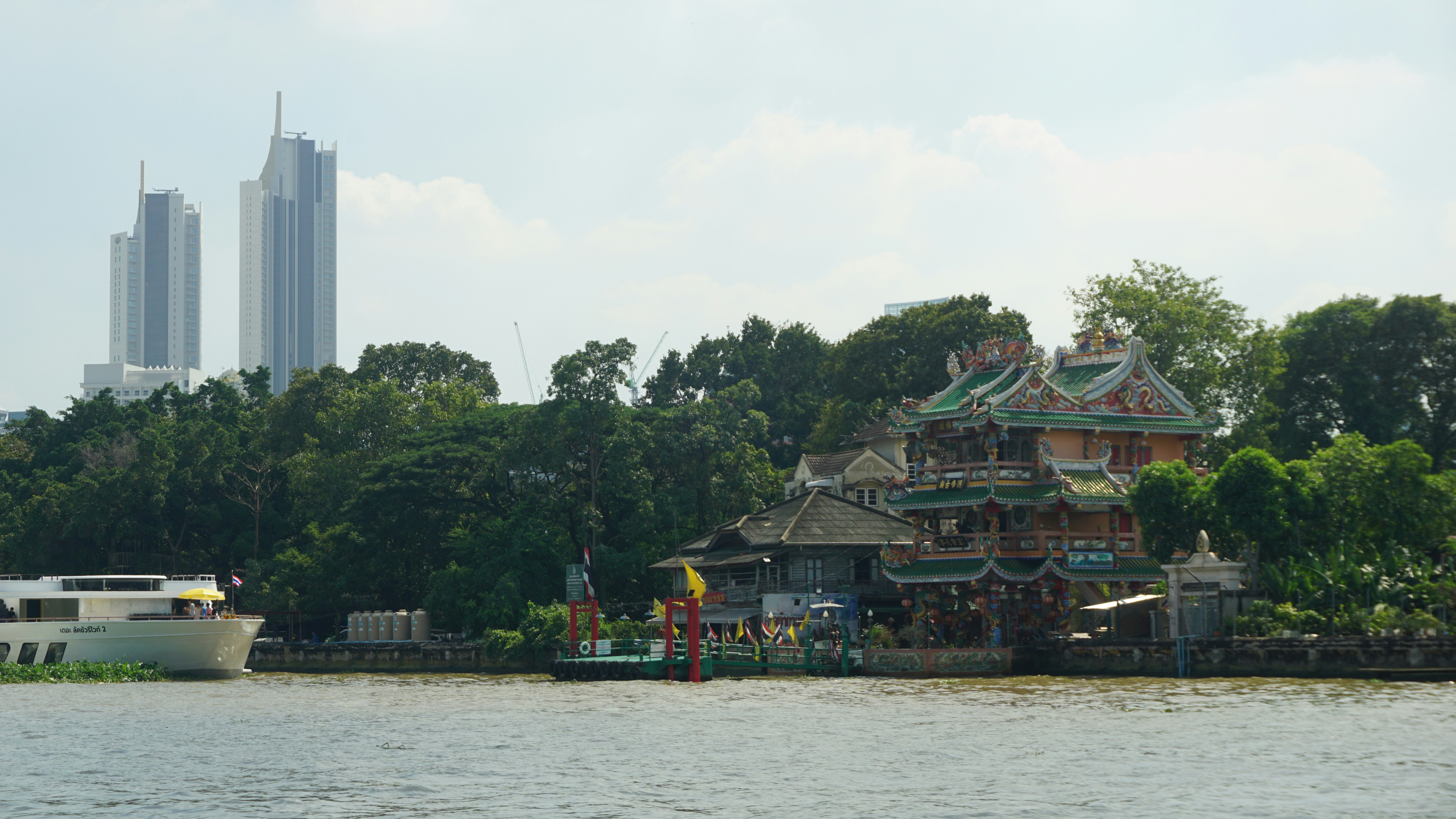 Temple by the River Beneath Modern Towers