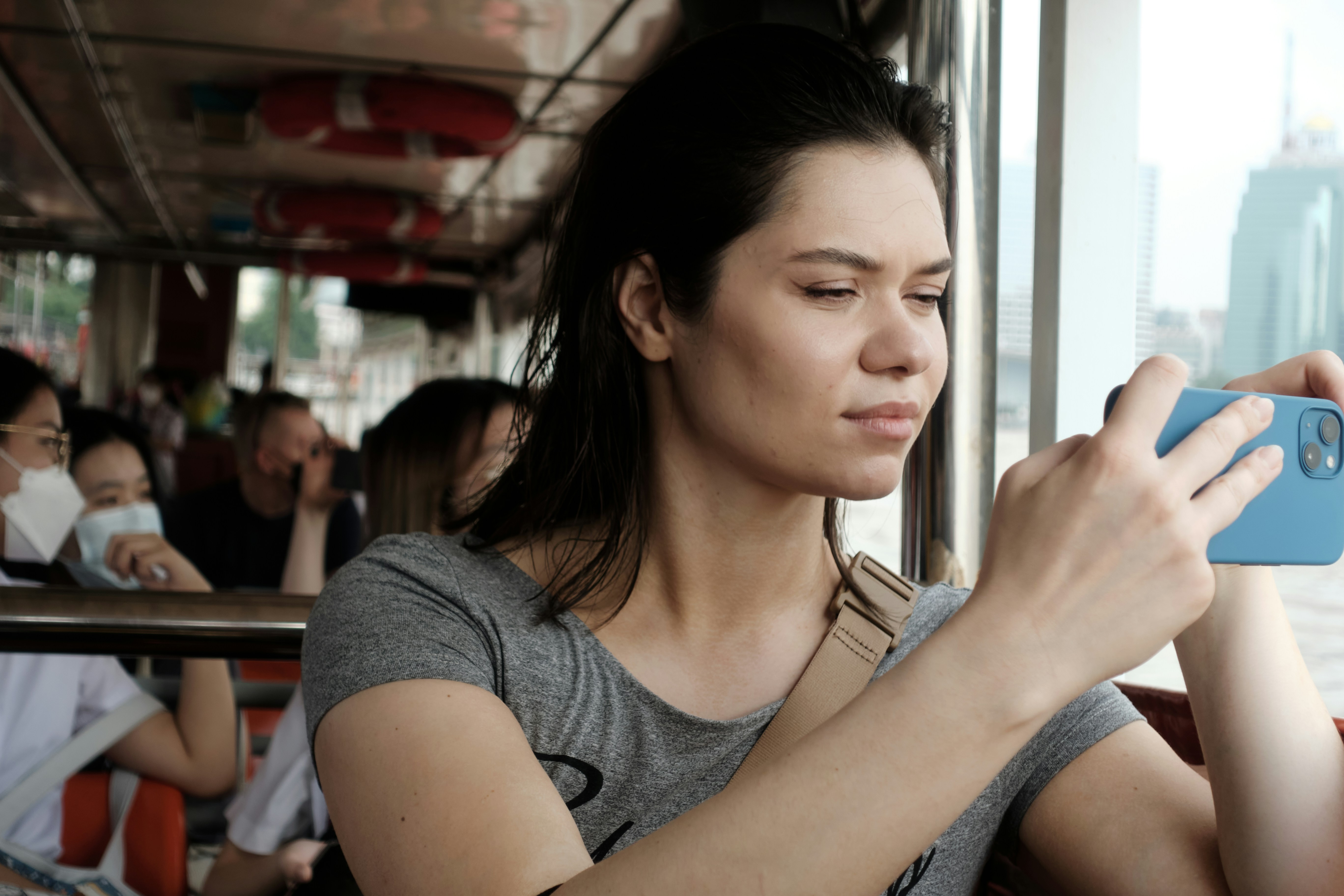 Woman taking a picture with her phone on a boat.