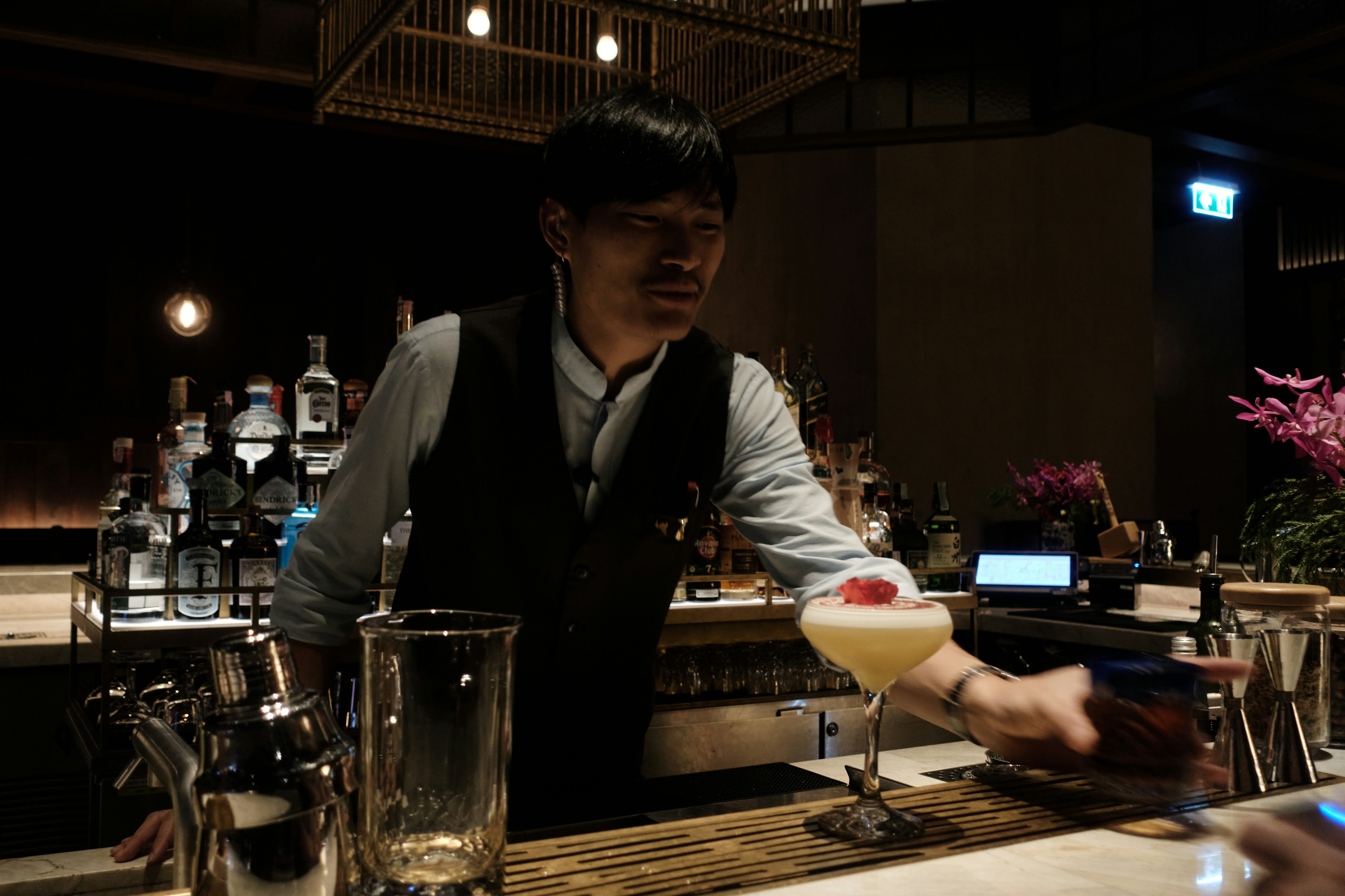Midnight Bartender in Softly Lit Potion of Glasses