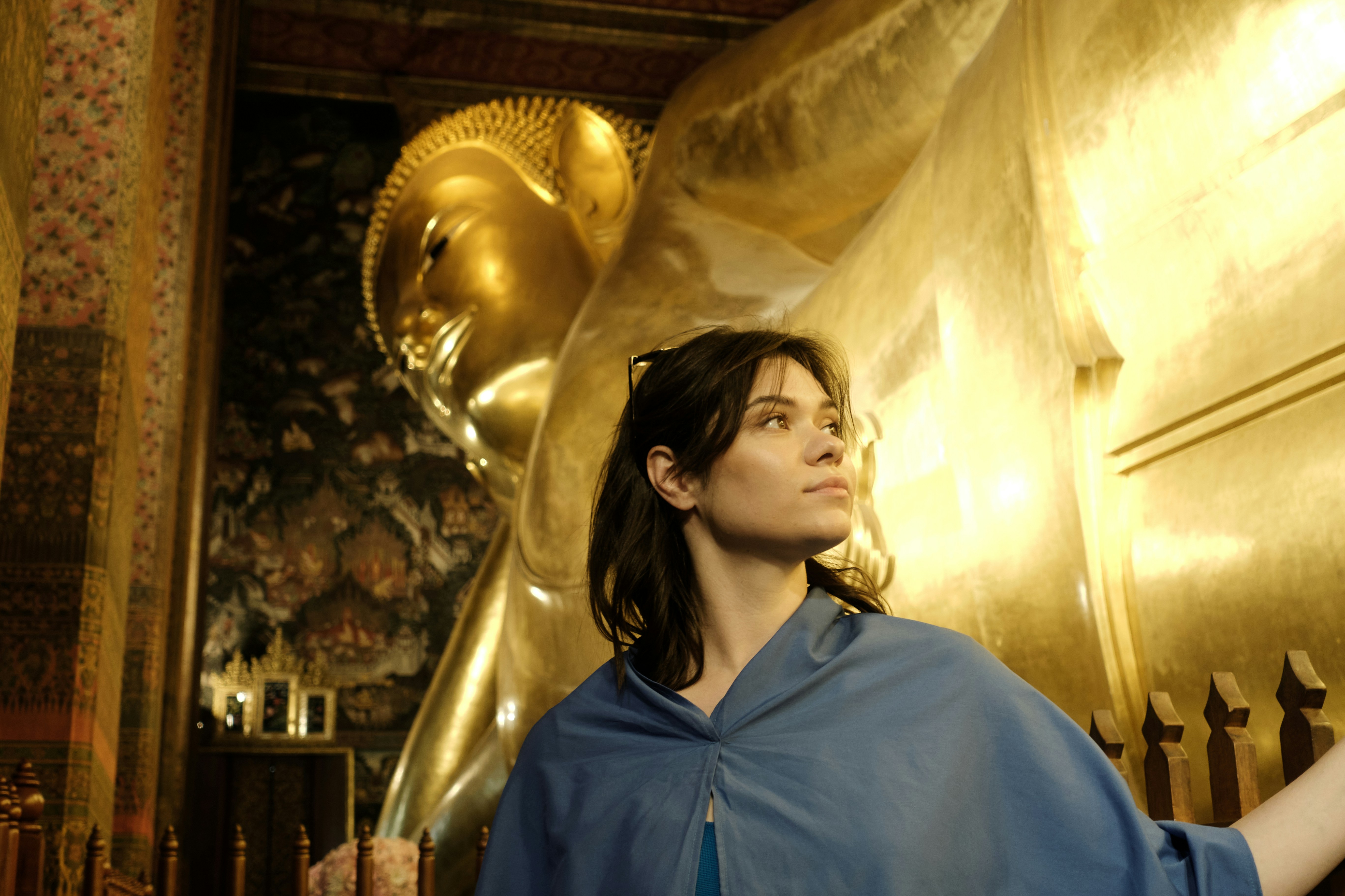 Blue Cloak and Golden Quiet: A Portrait Beneath a Serene Buddha