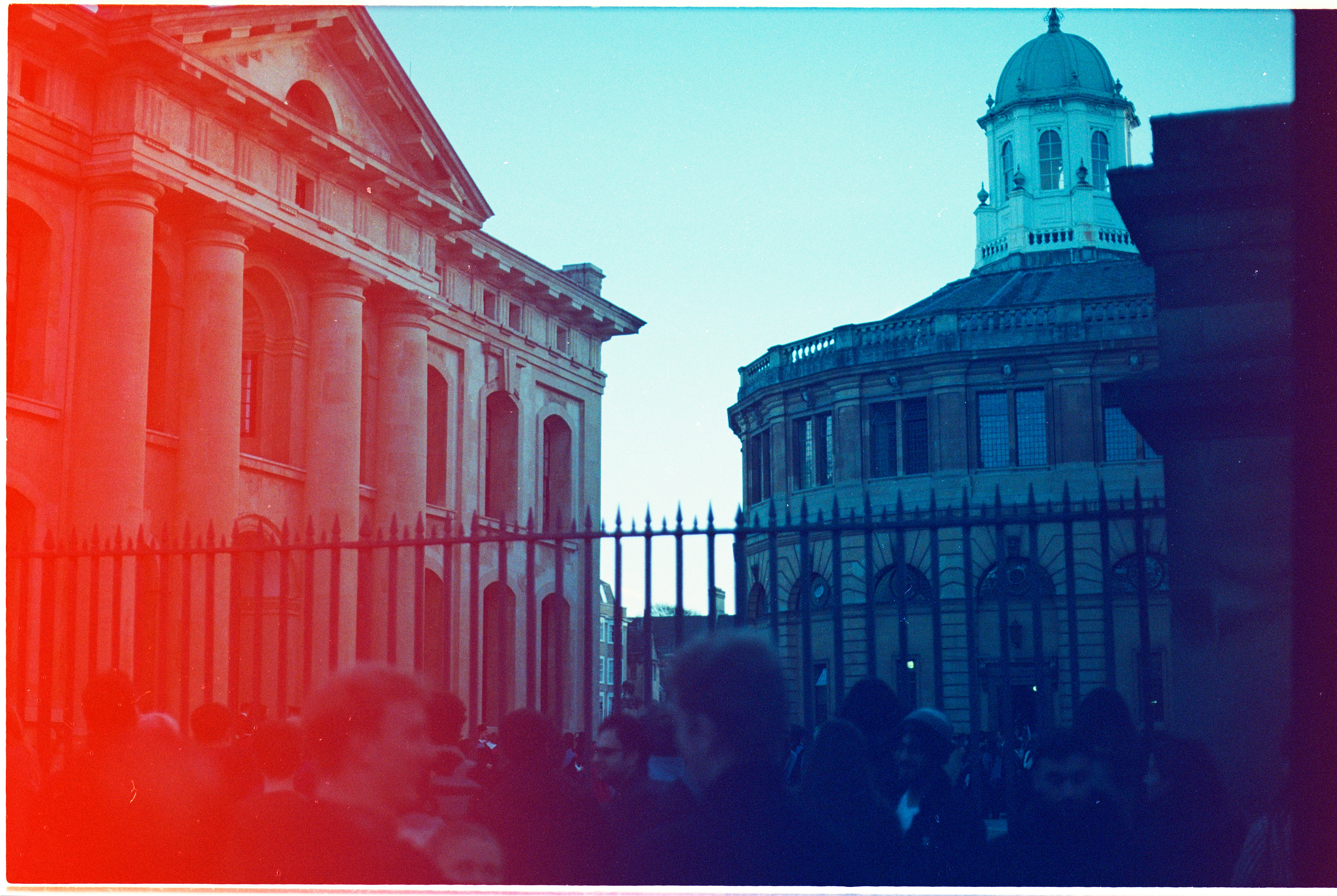 Buildings with columns and a dome under a gradient sky.
