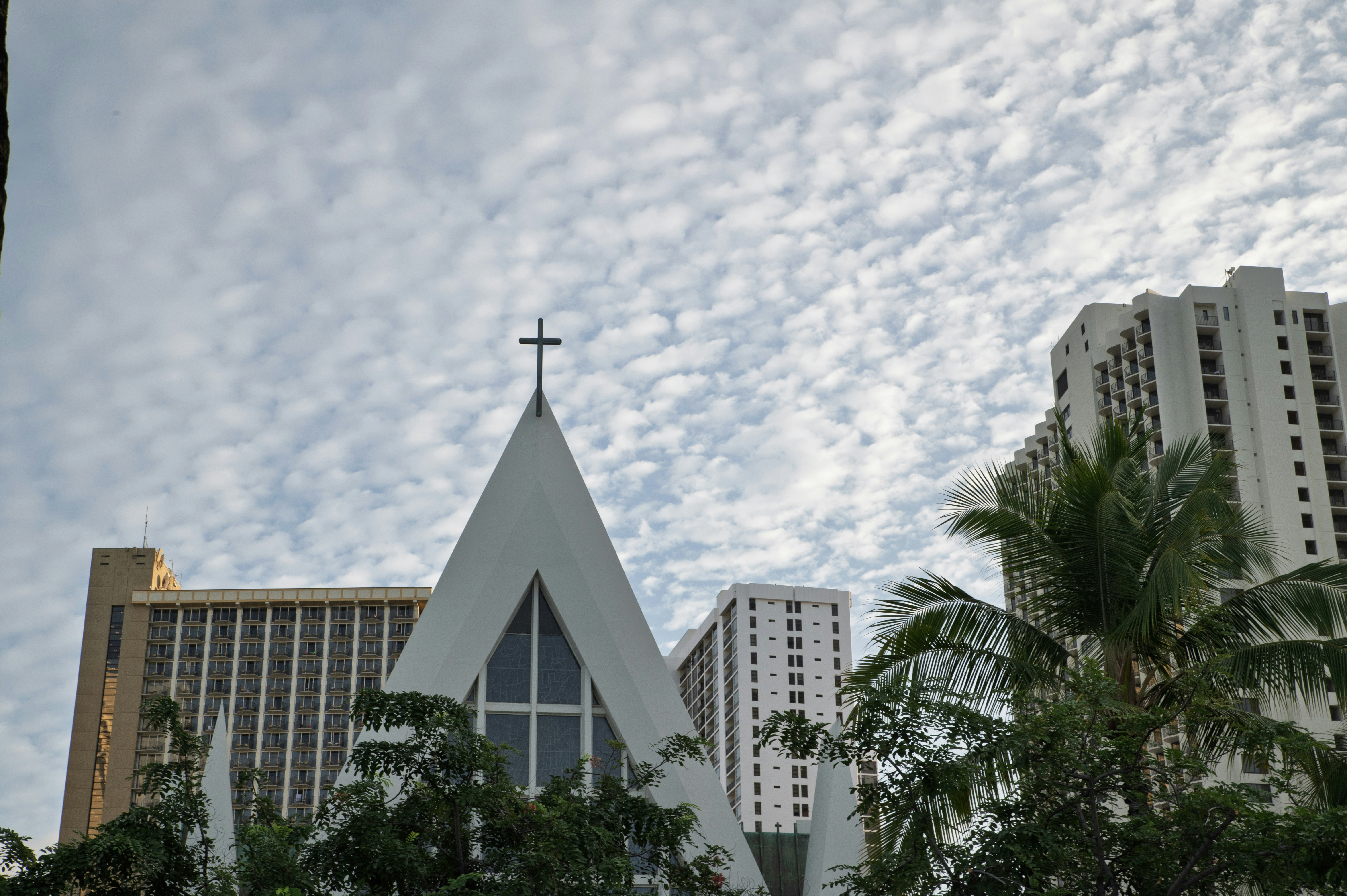 Cross atop the A-frame Church Reaches Toward a Sky-scattered Day