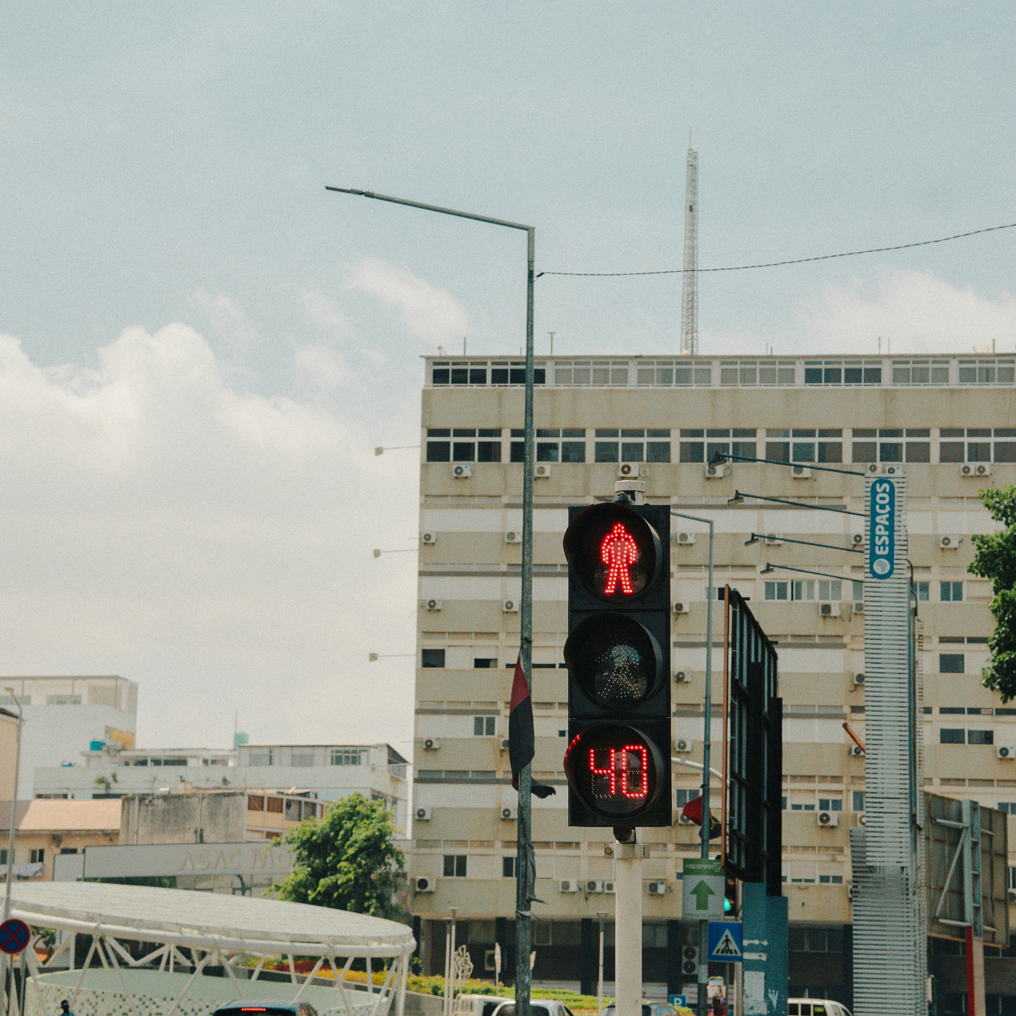 Urban Signal: Red Pedestrian Light Above a Busy Street