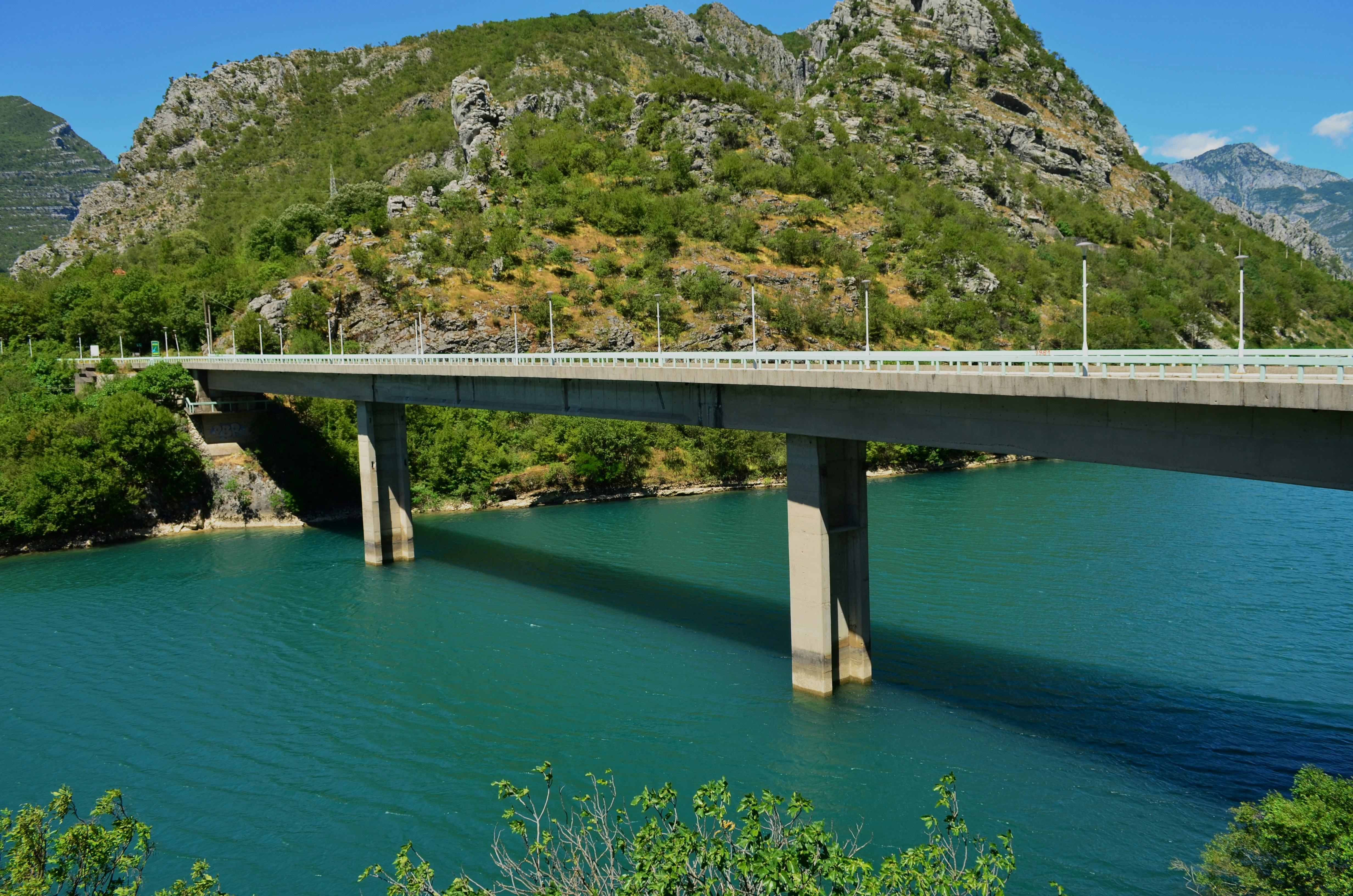 Bridge Span over Turquoise Waters—Geometric Calm Amidst Rugged Limestone