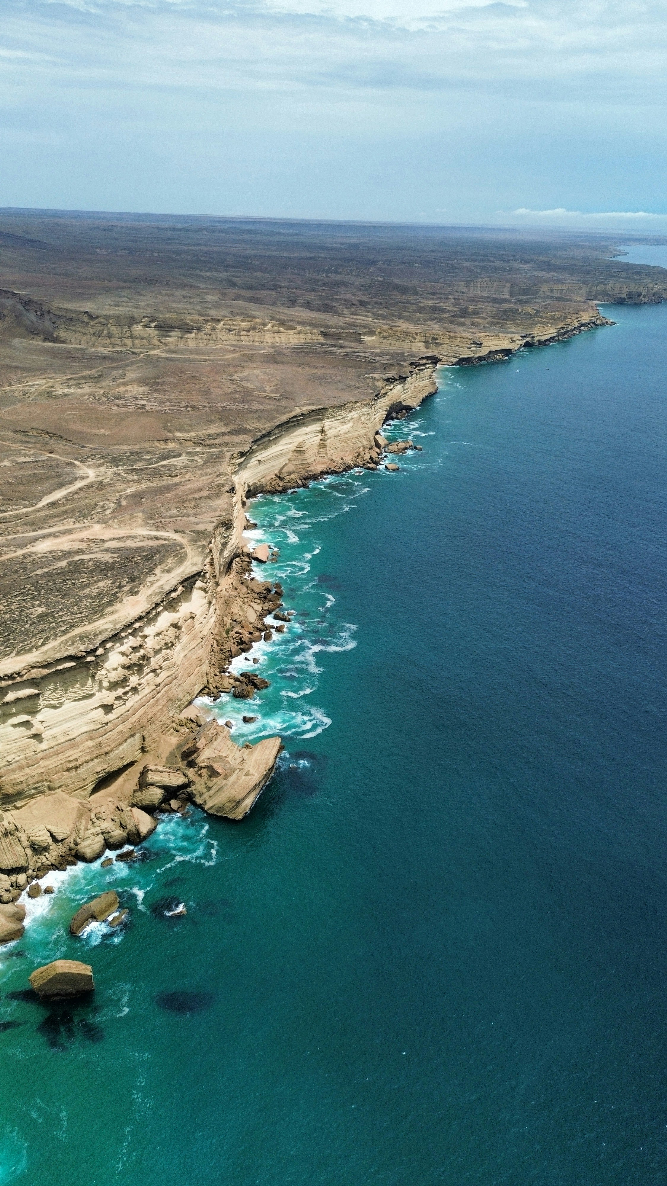 Cliff Coastline Carved by Sea: Turquoise Waters Meet Weathered Terraces